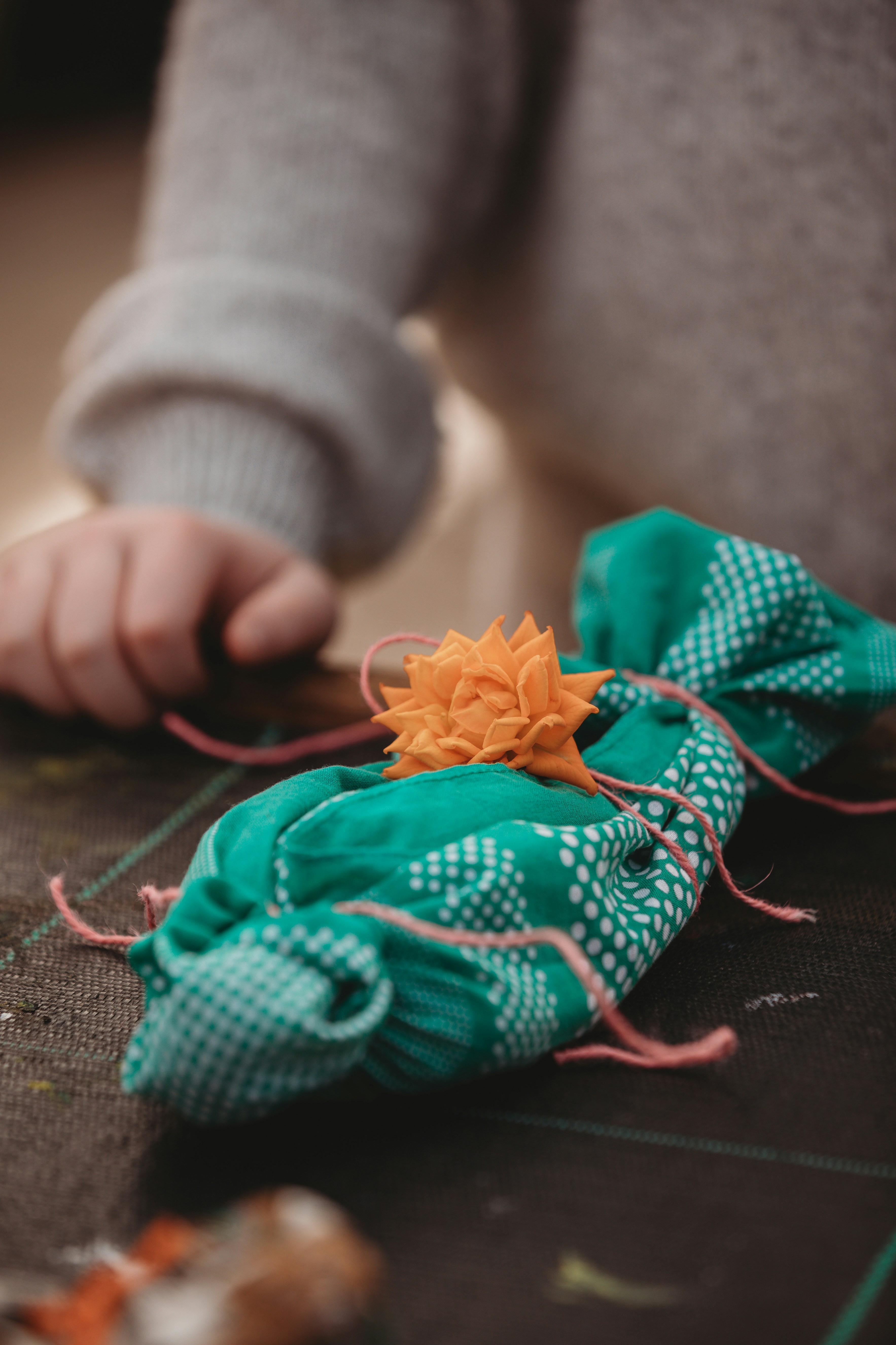 Colorful Fabric and Orange Flower: A Soft Focus Moment of Craft and Curiosity