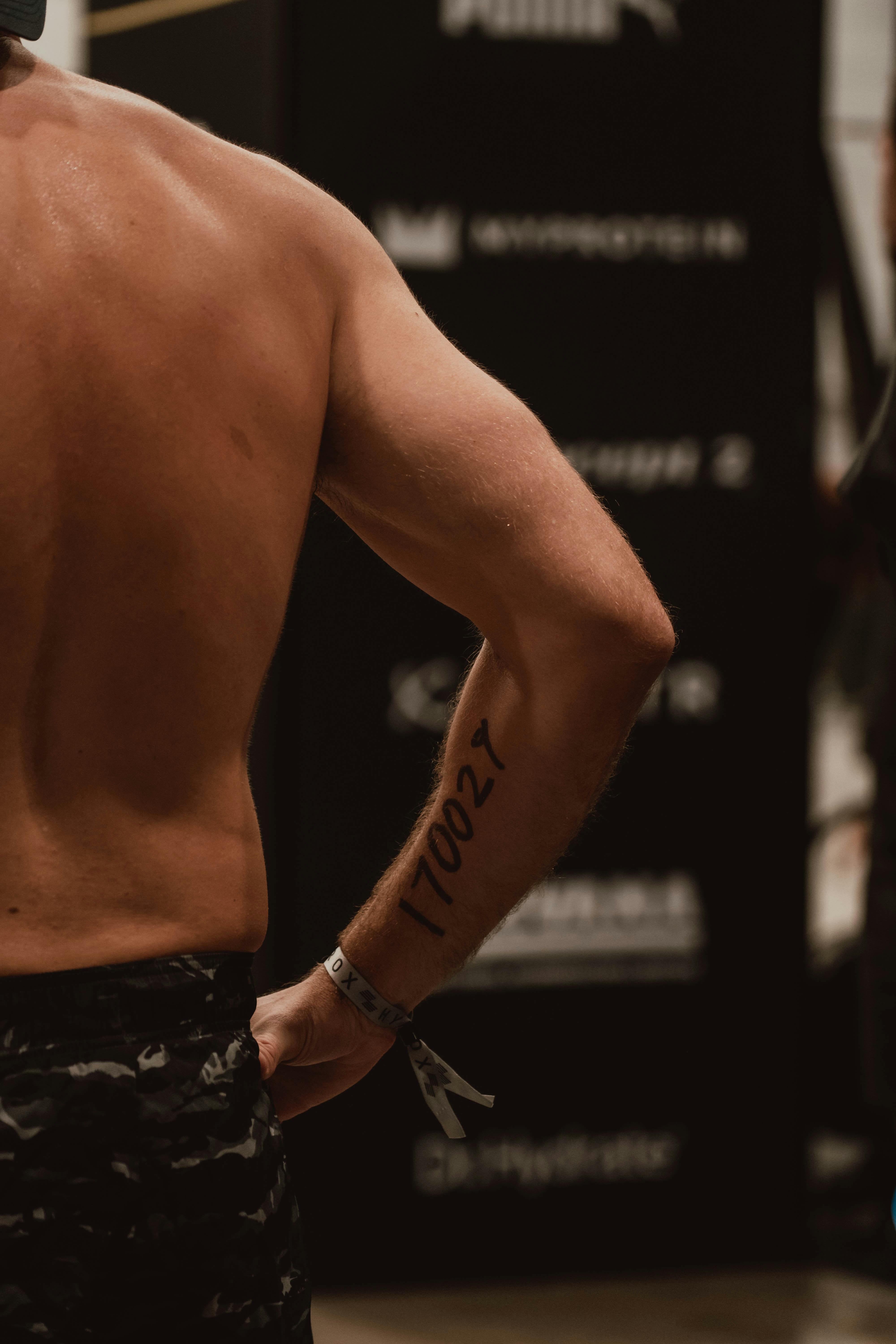 Mid-Back Portrait: Warrior with Arm Tattoo in Training Arena