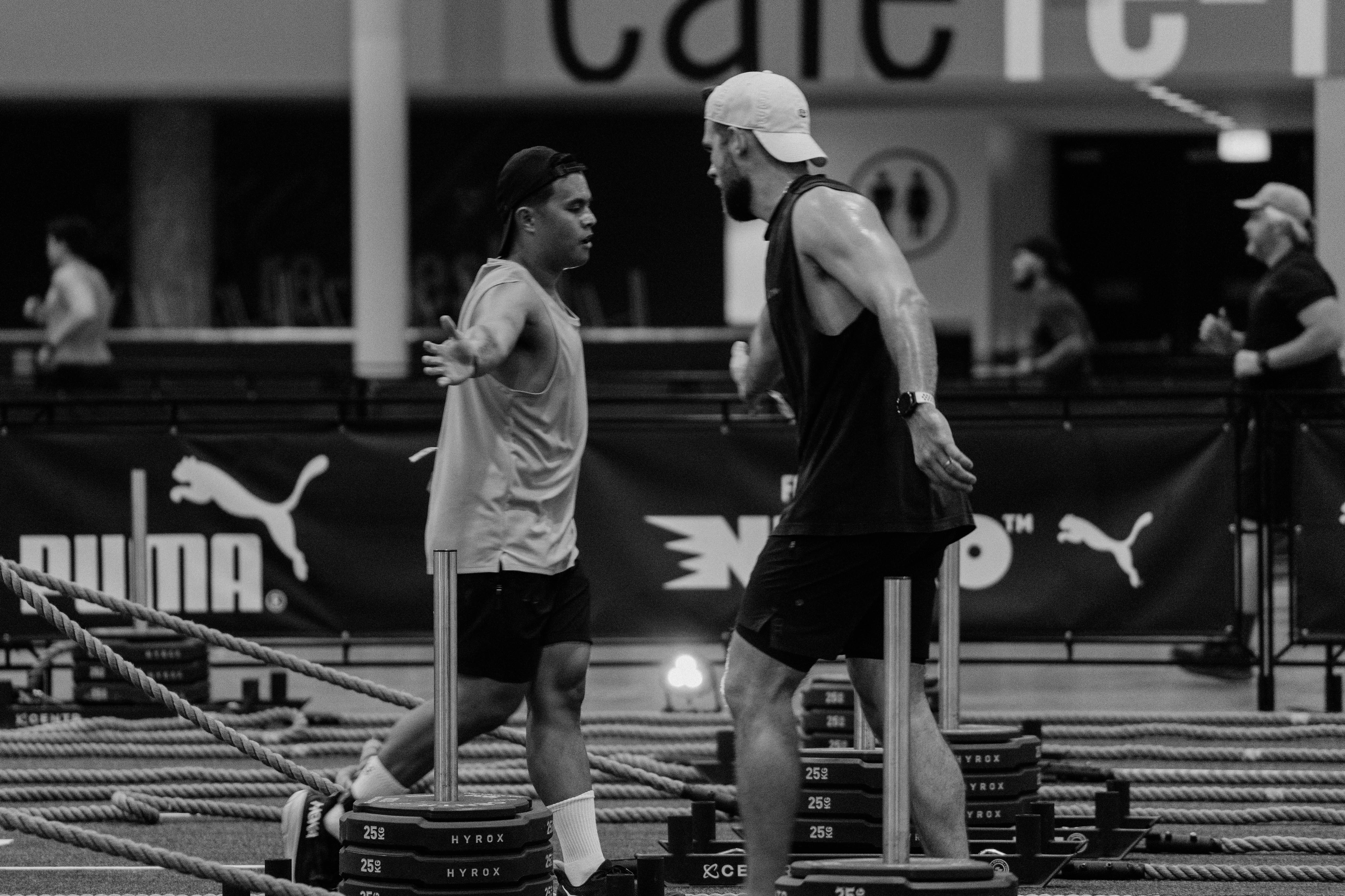 Rivals in Focus: Two athletes share a quiet moment between sets at the training arena