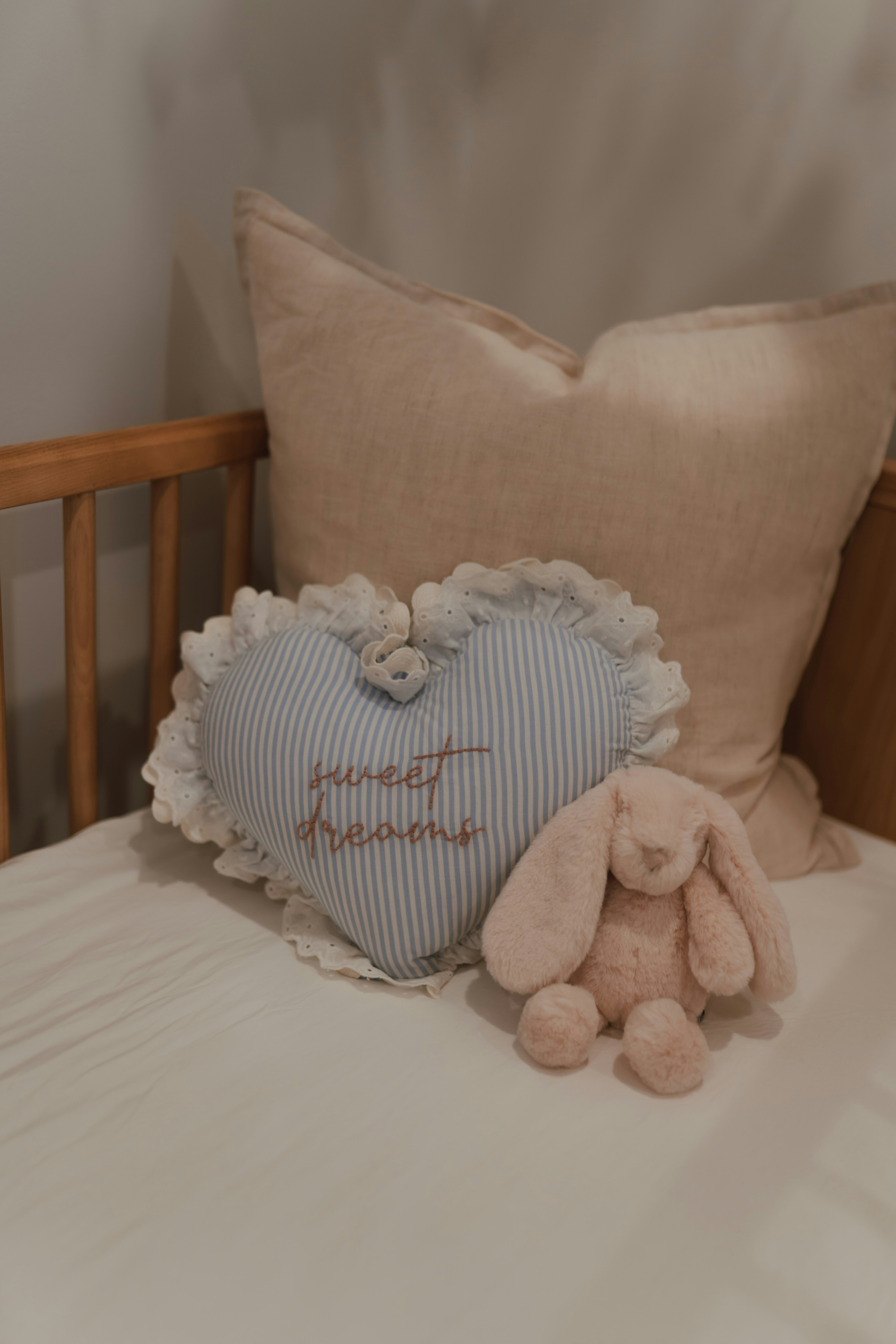 Soft Harmony: Heart-Shaped Pillow and Plush Bunny on a Cozy Bed