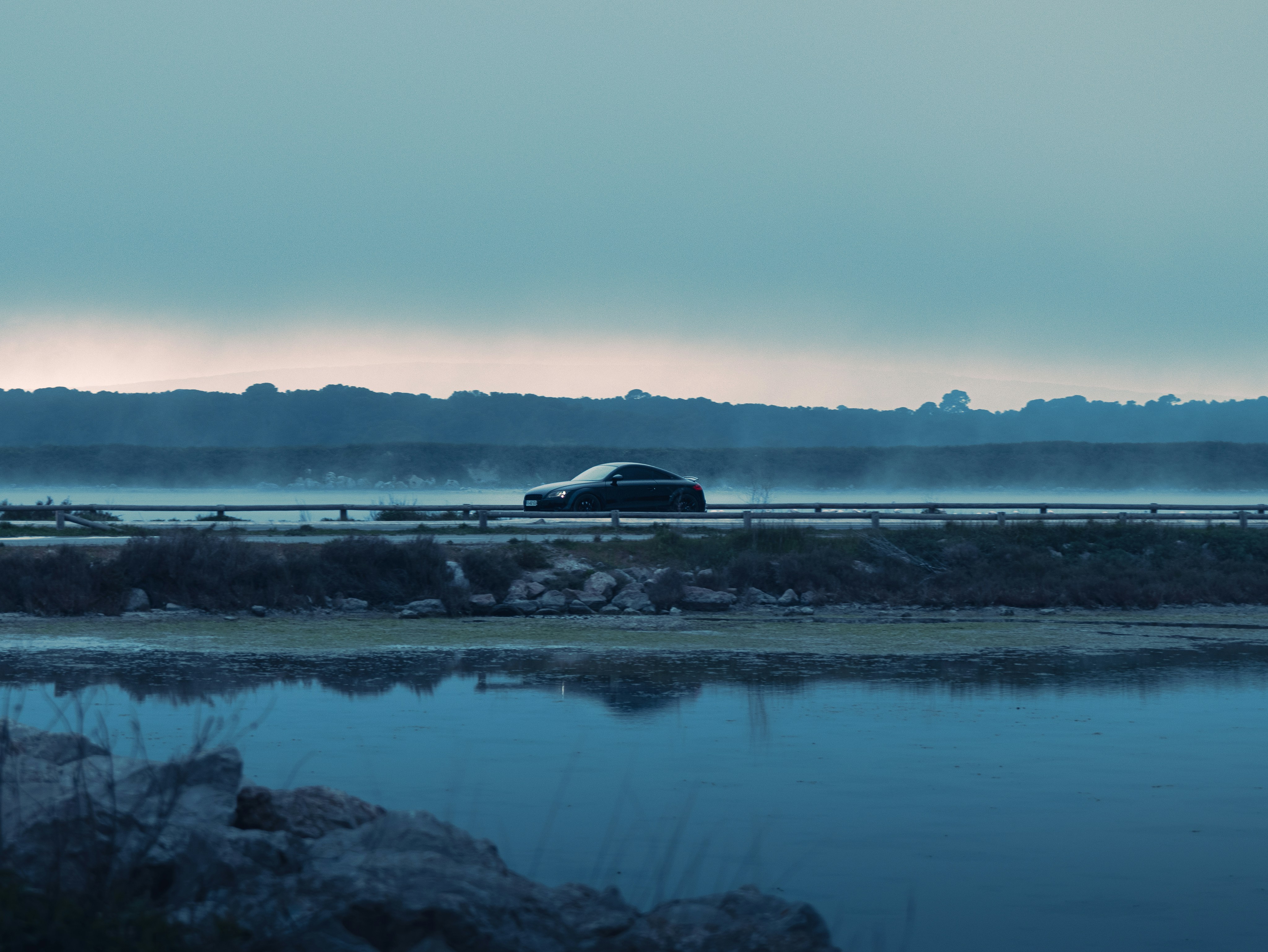Midday Highway Mirage: A lone sedan on a distant bridge