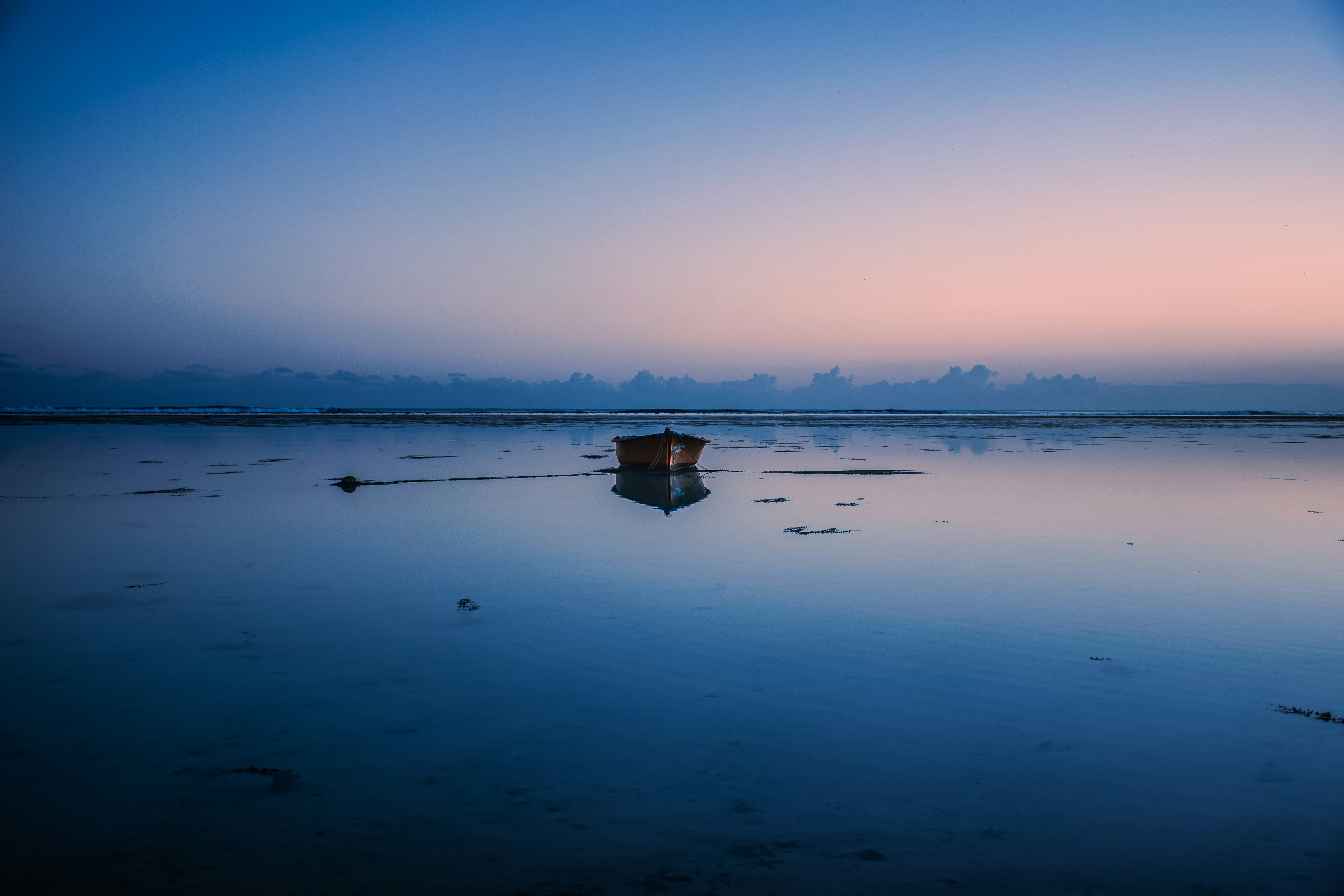 Silence Afloat: A Lone Boat on a Slumbering Sea at Dawn