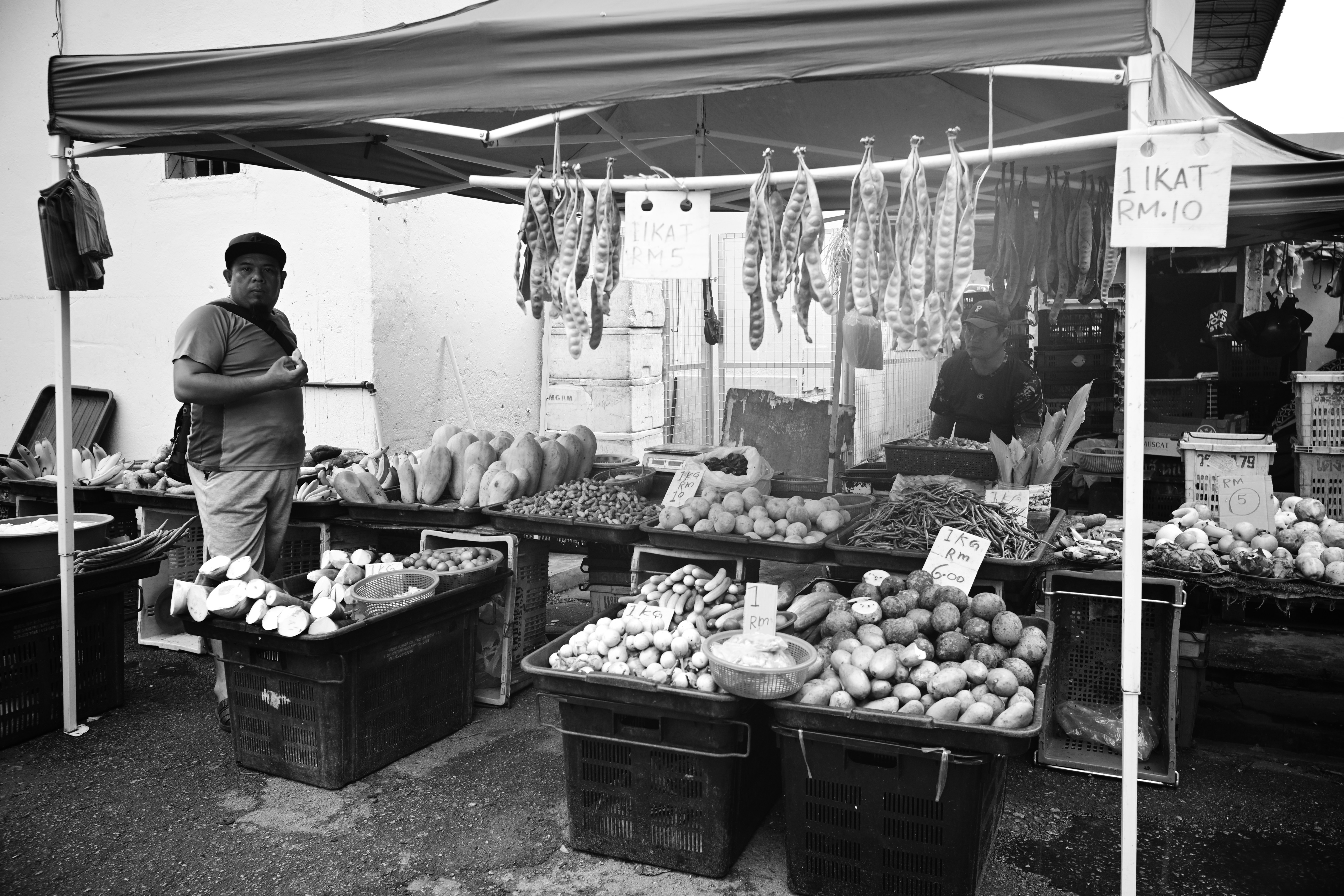 Market Stand at Dusk: A Quiet Portrait of Fresh Produce and a Solitary Vendor