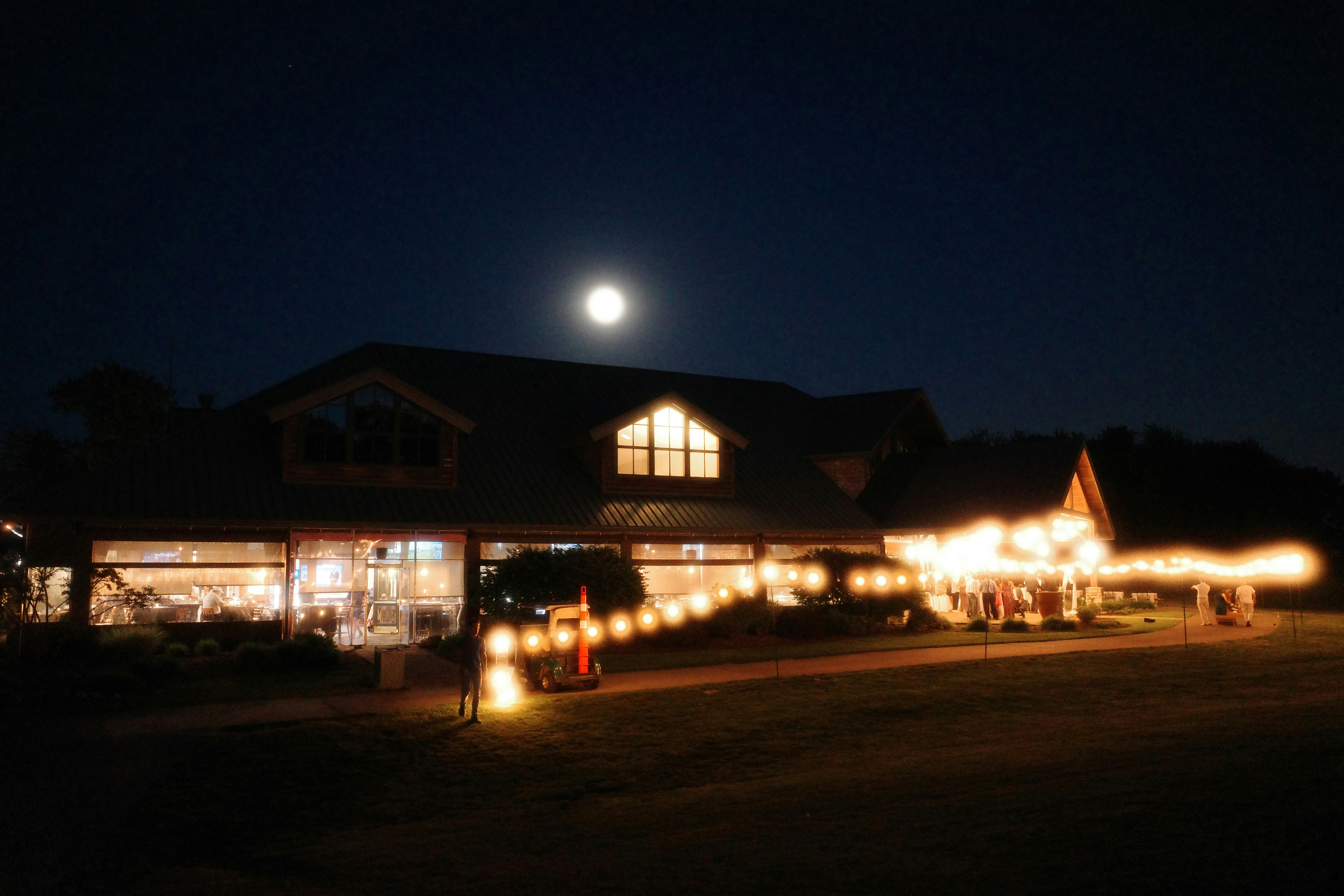 Moonlit Feast: Warm Lights Outline a Cozy Dinner Barn