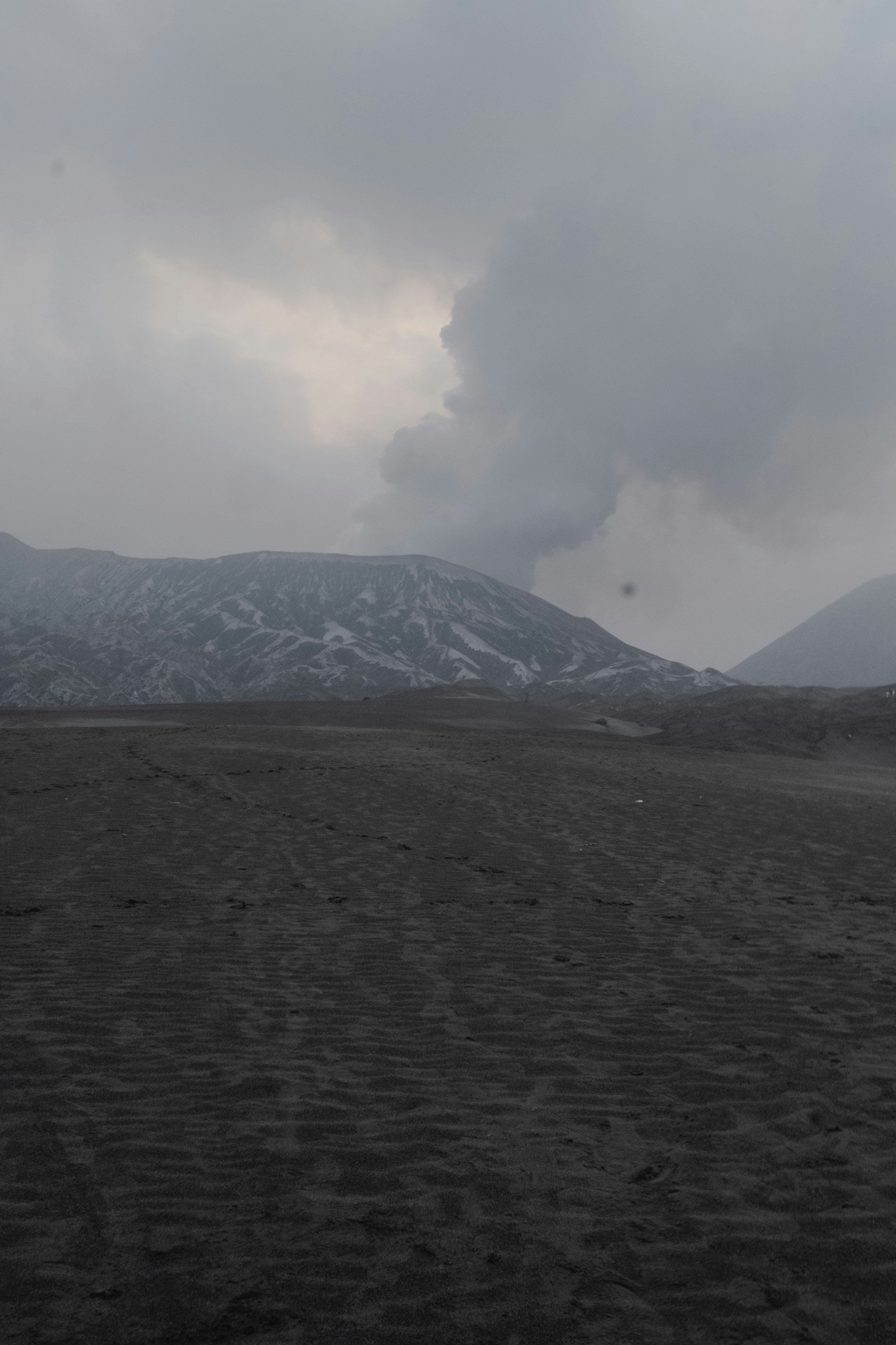 Storm-Lashed Plateau: Snow-sprinkled Rim Beneath Looming Clouds