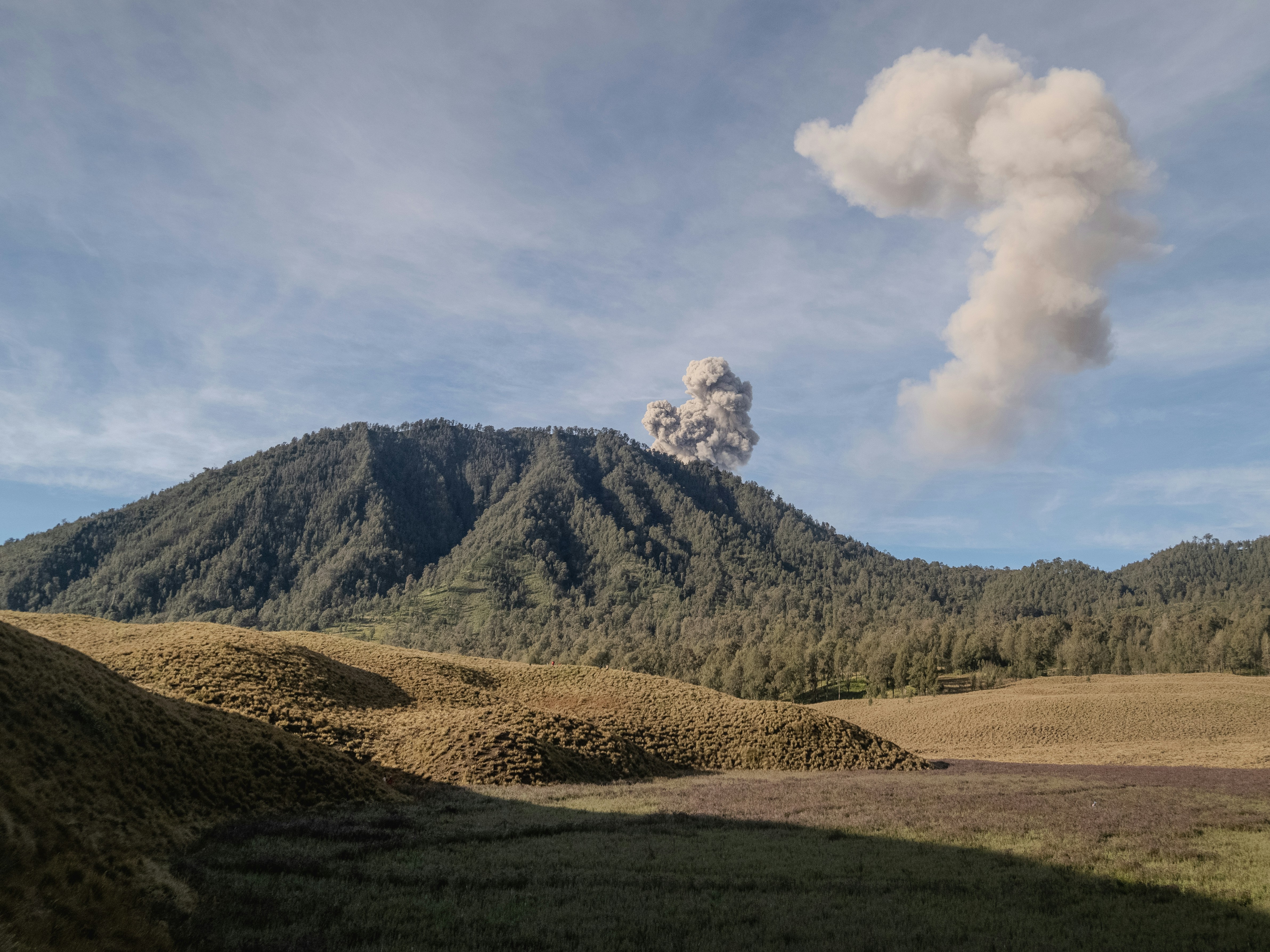 Rising Colossus: A Volcanic plume over a rolling ridge