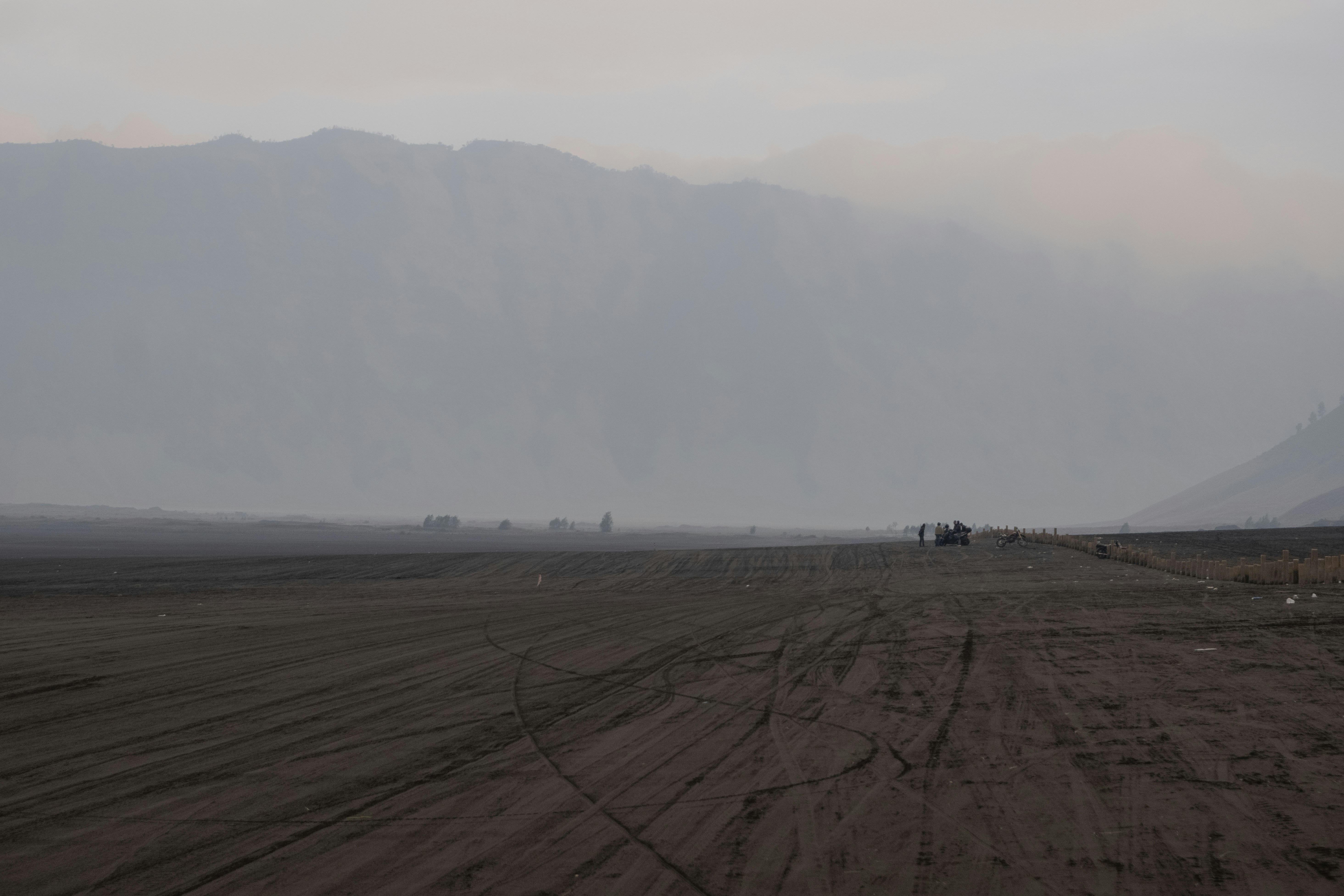 Dusty Plain at Dusk: Tracks Fade into a Misty Horizon