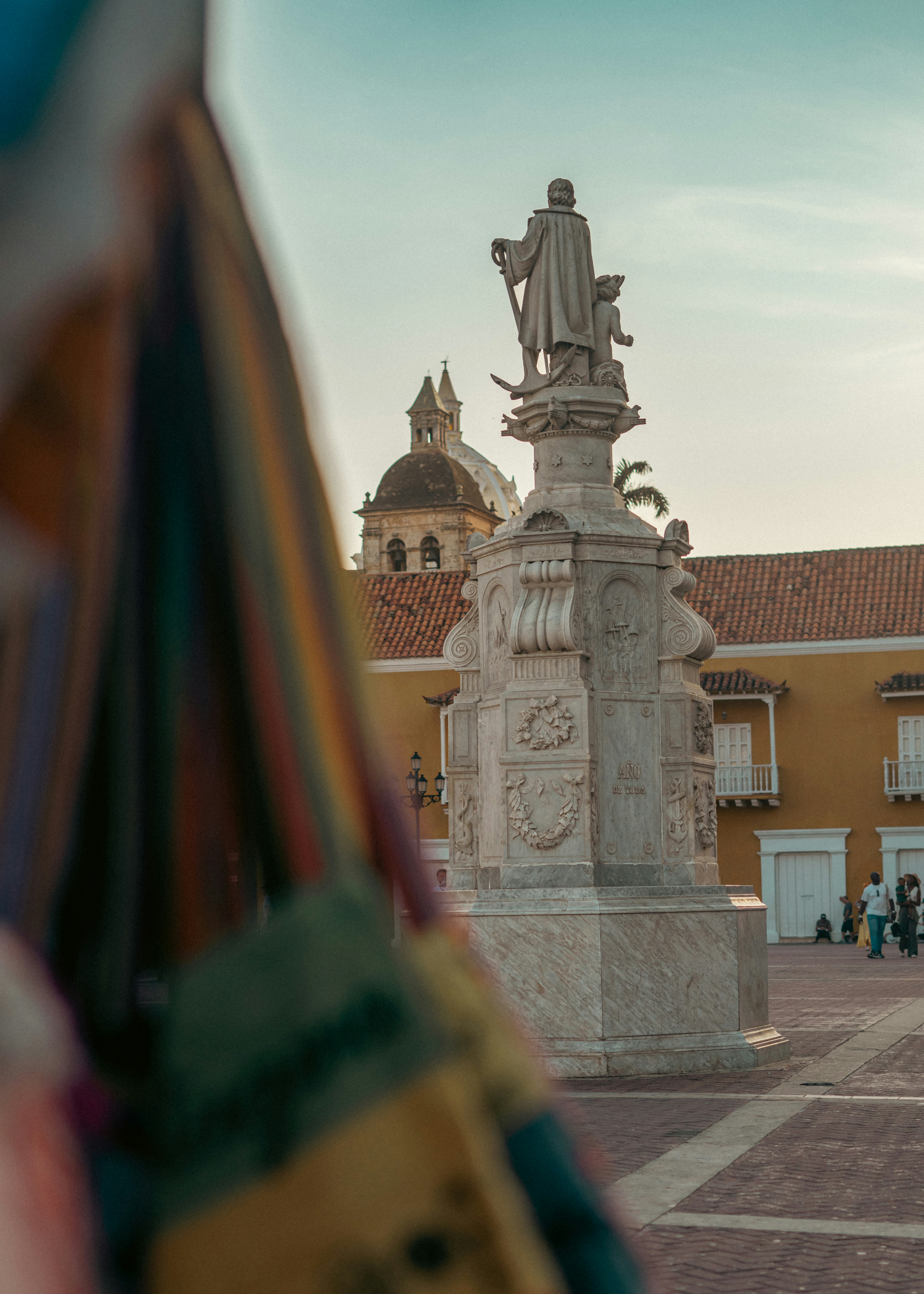 Statue and Plaza: A Quiet Corner Framed by Colorful Cloths
