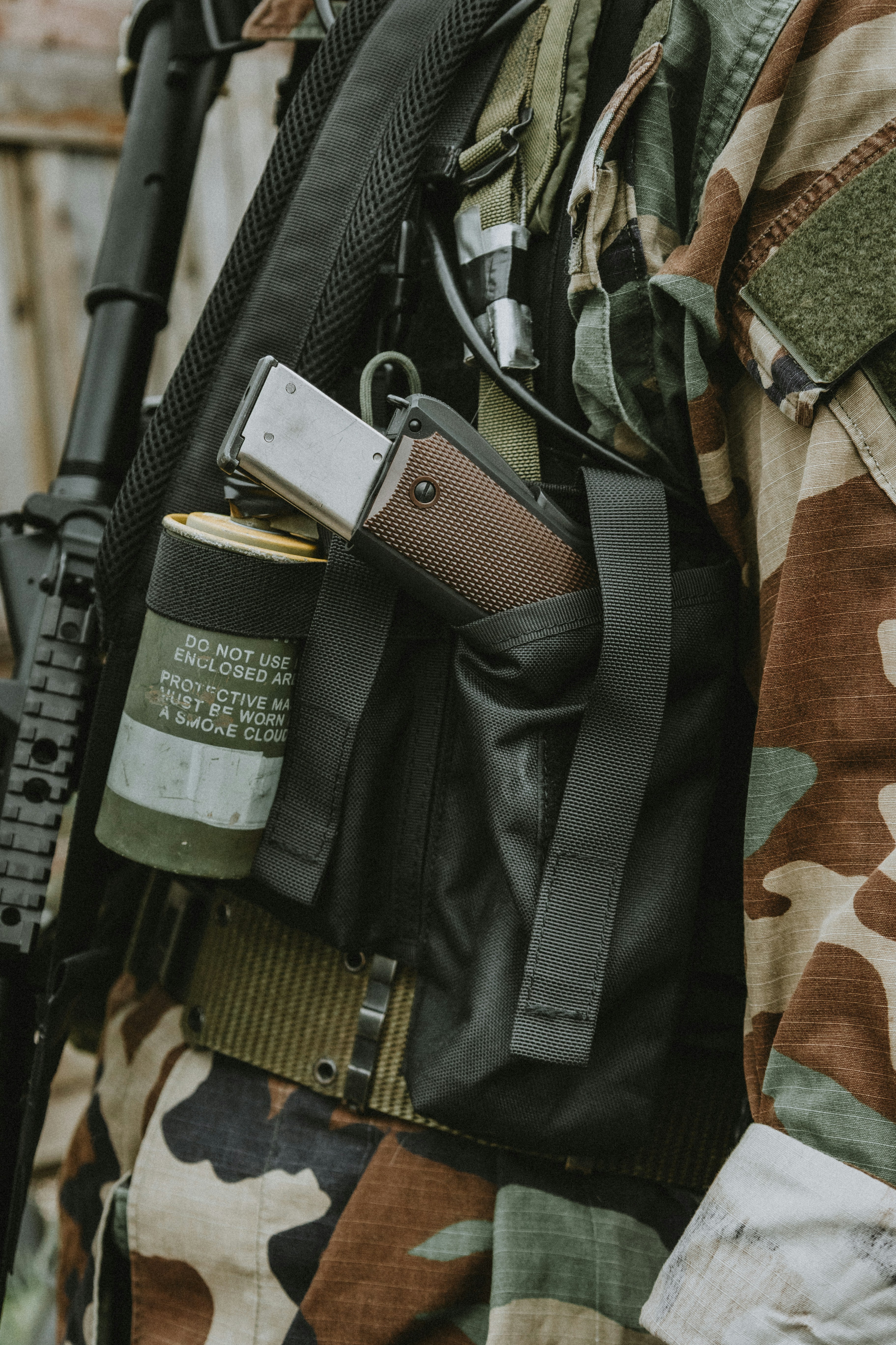 Camouflage Gear: Close-Up of Utility Vest with Pistol Grip and Magazine in a Tactically Ready Setup