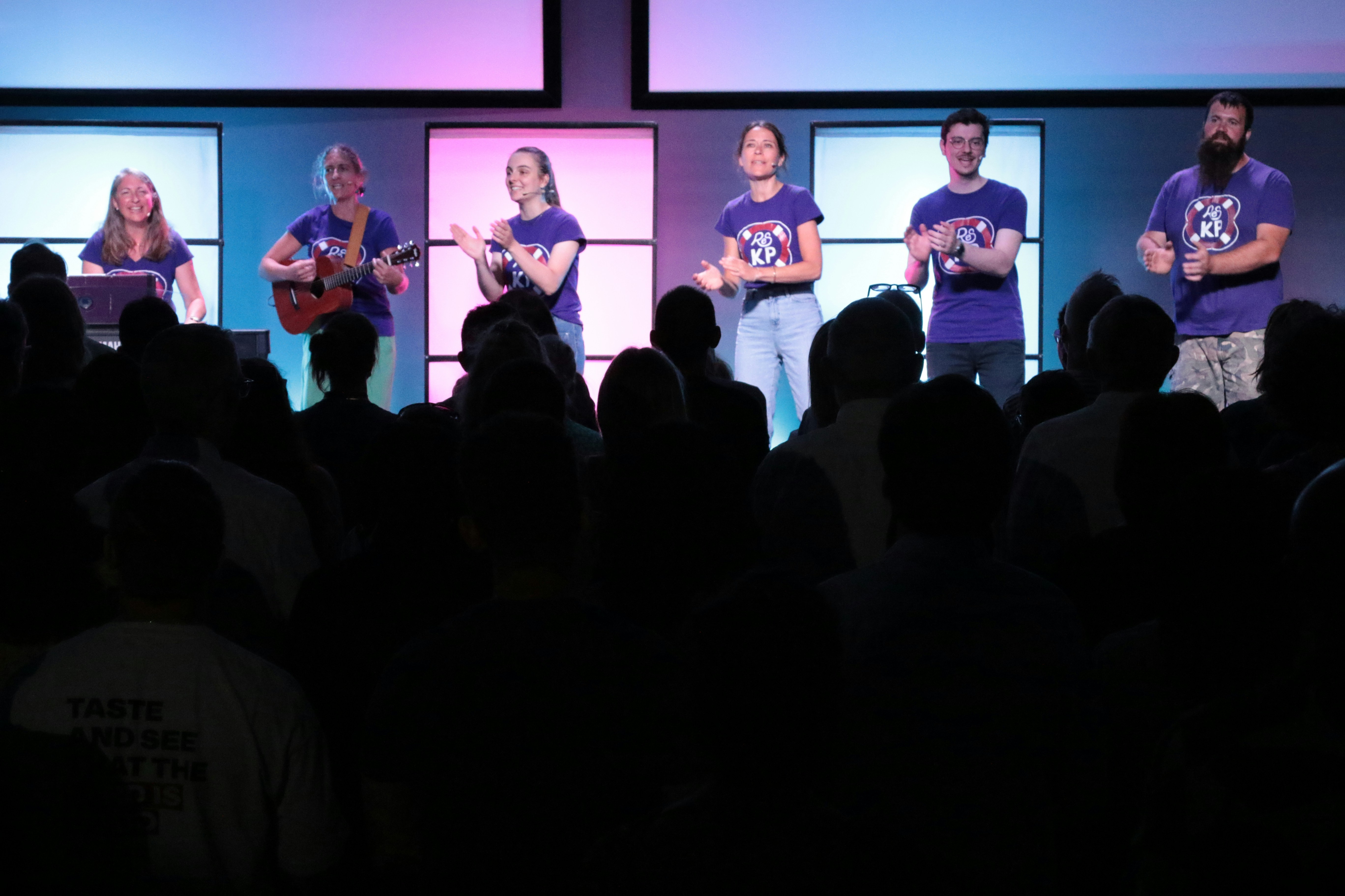 Stage Choir: A Row of Performers Under Neon Panels