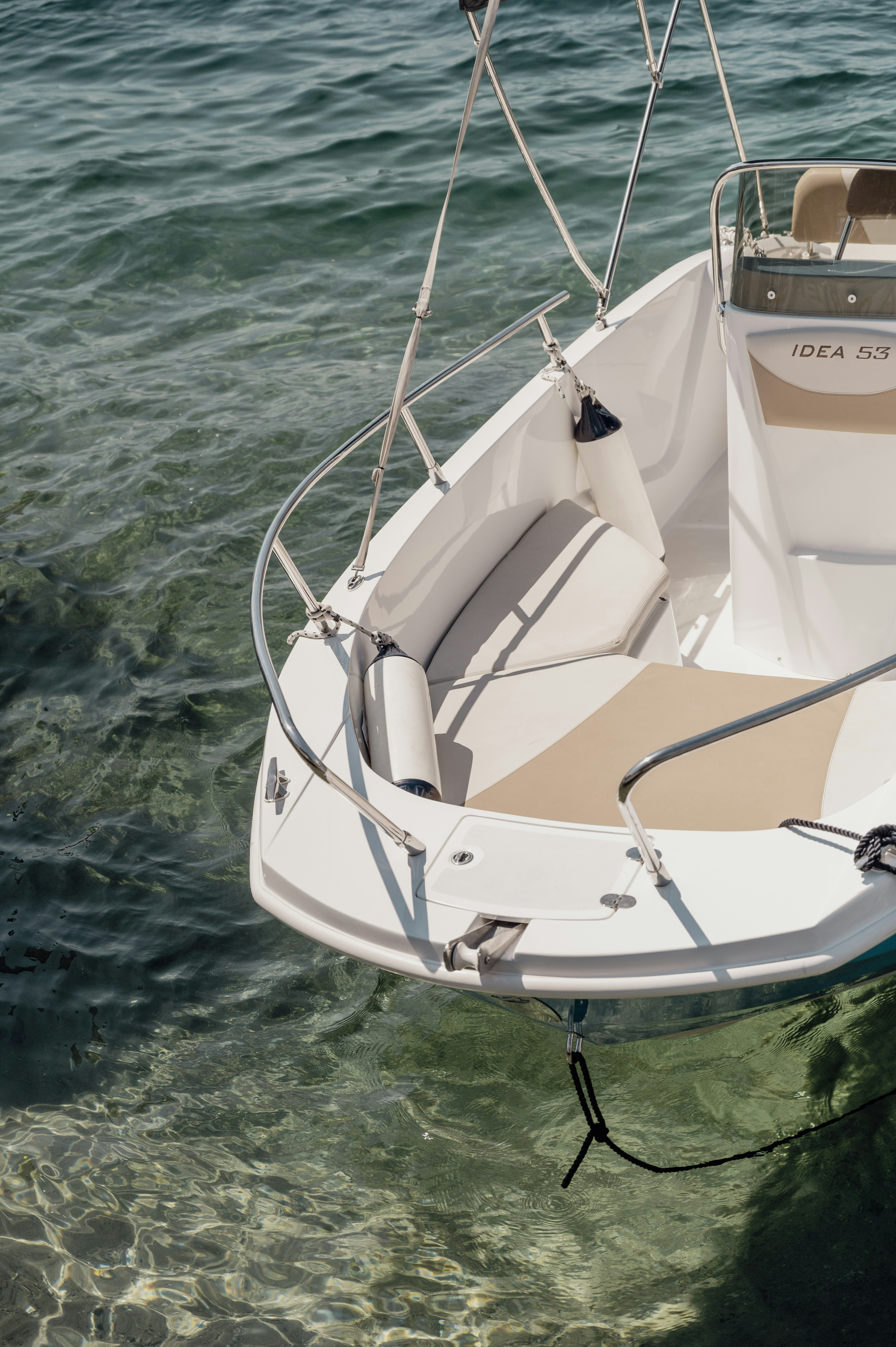 A Quiet Bow Ride: White Boat Resting Over Clear Sea