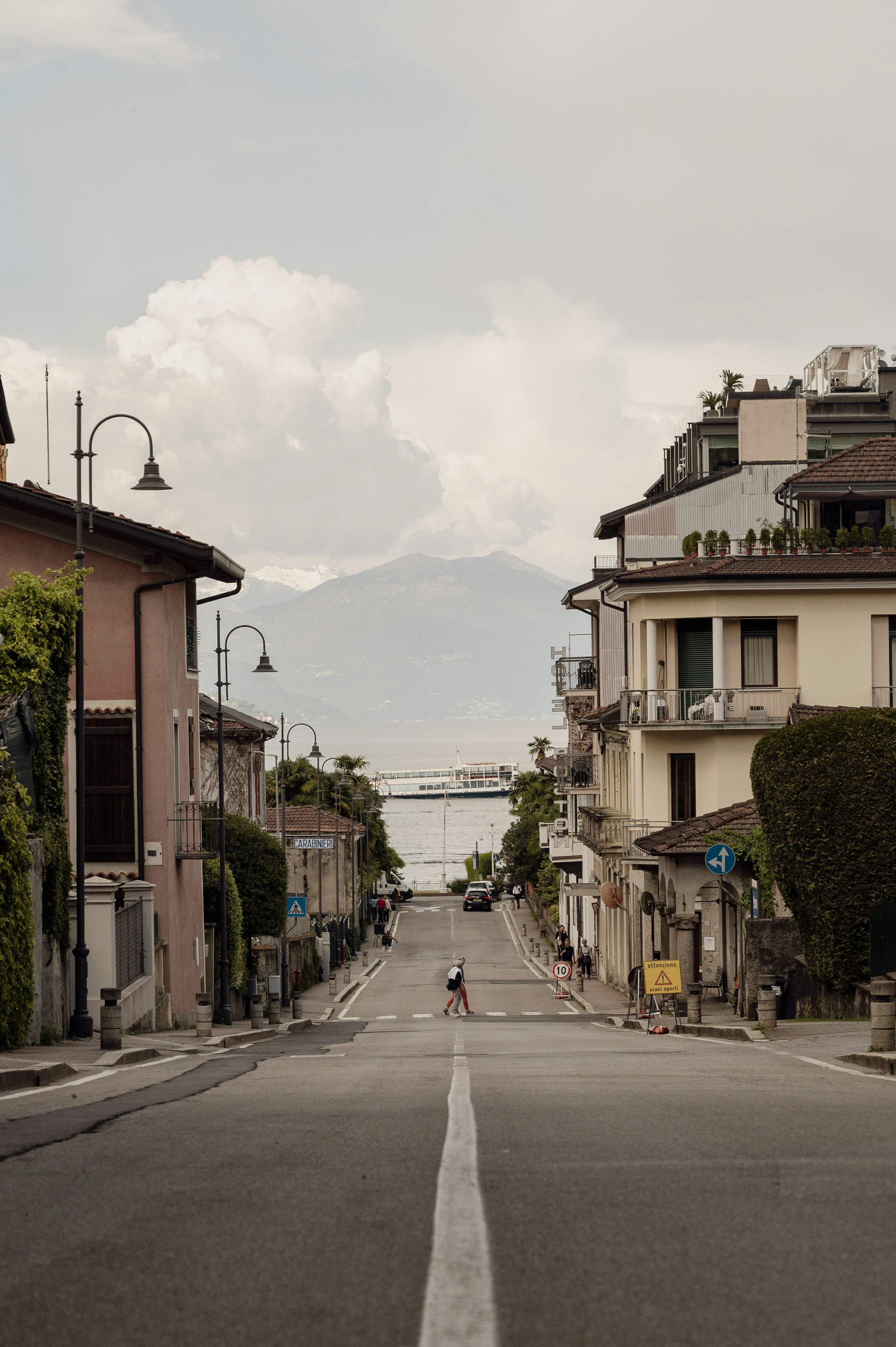 Street toward the harbour: a sunlit valley between pastel buildings
