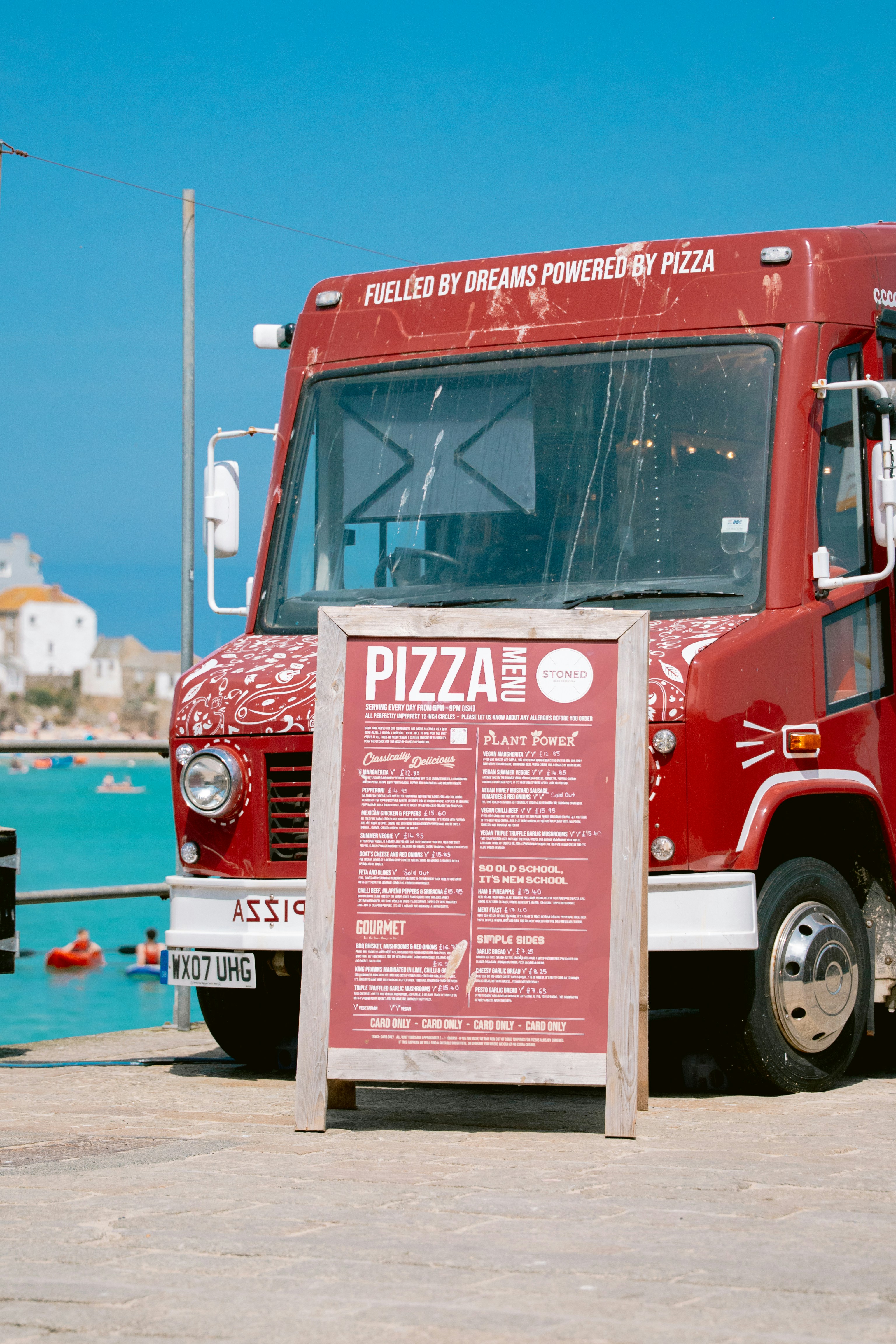 Pizza Truck at the Harbor: A Red Culinary Vessel by the Sea