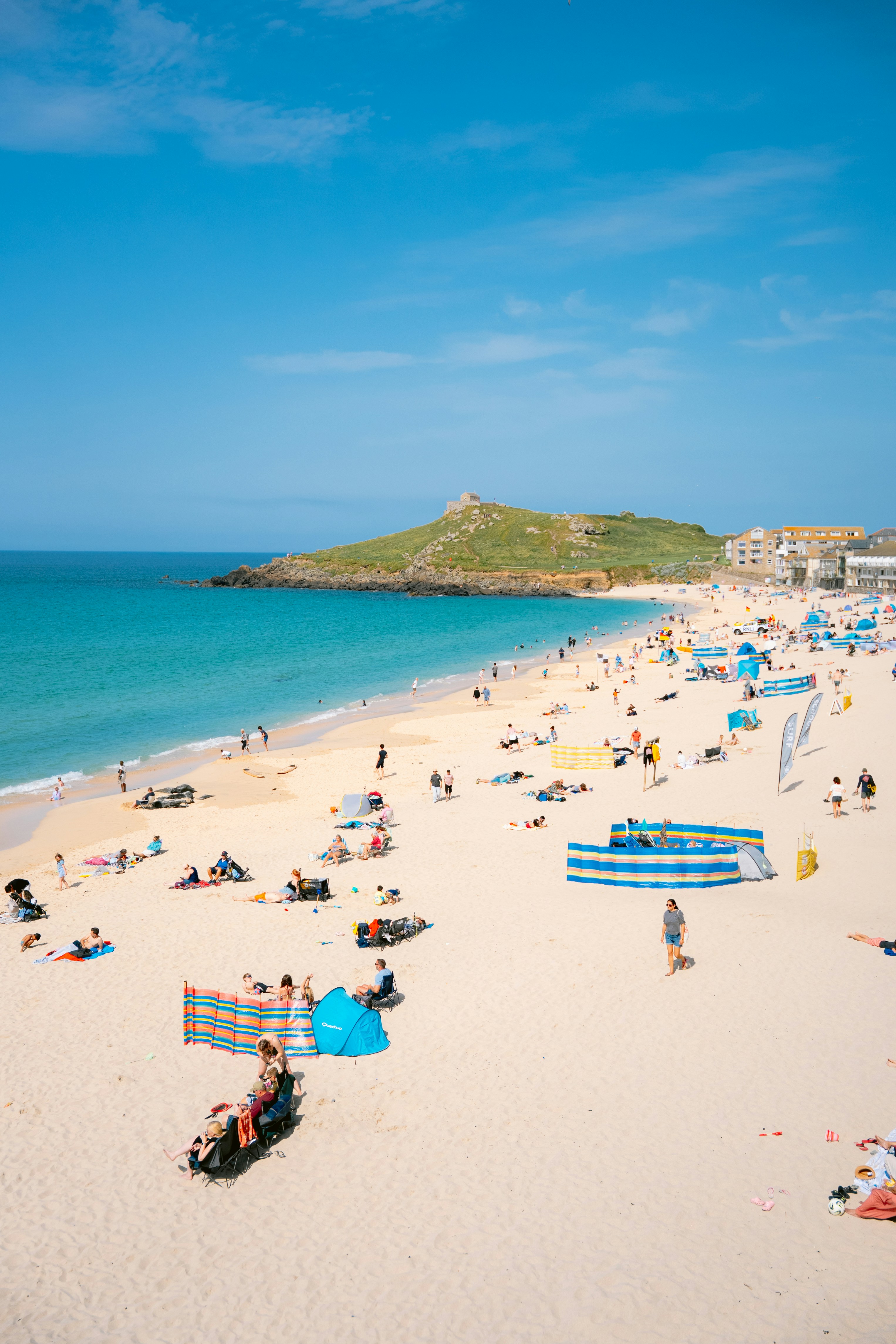Sunlit Beach Corridor: A Lively Shoreline Under a Clear Sky