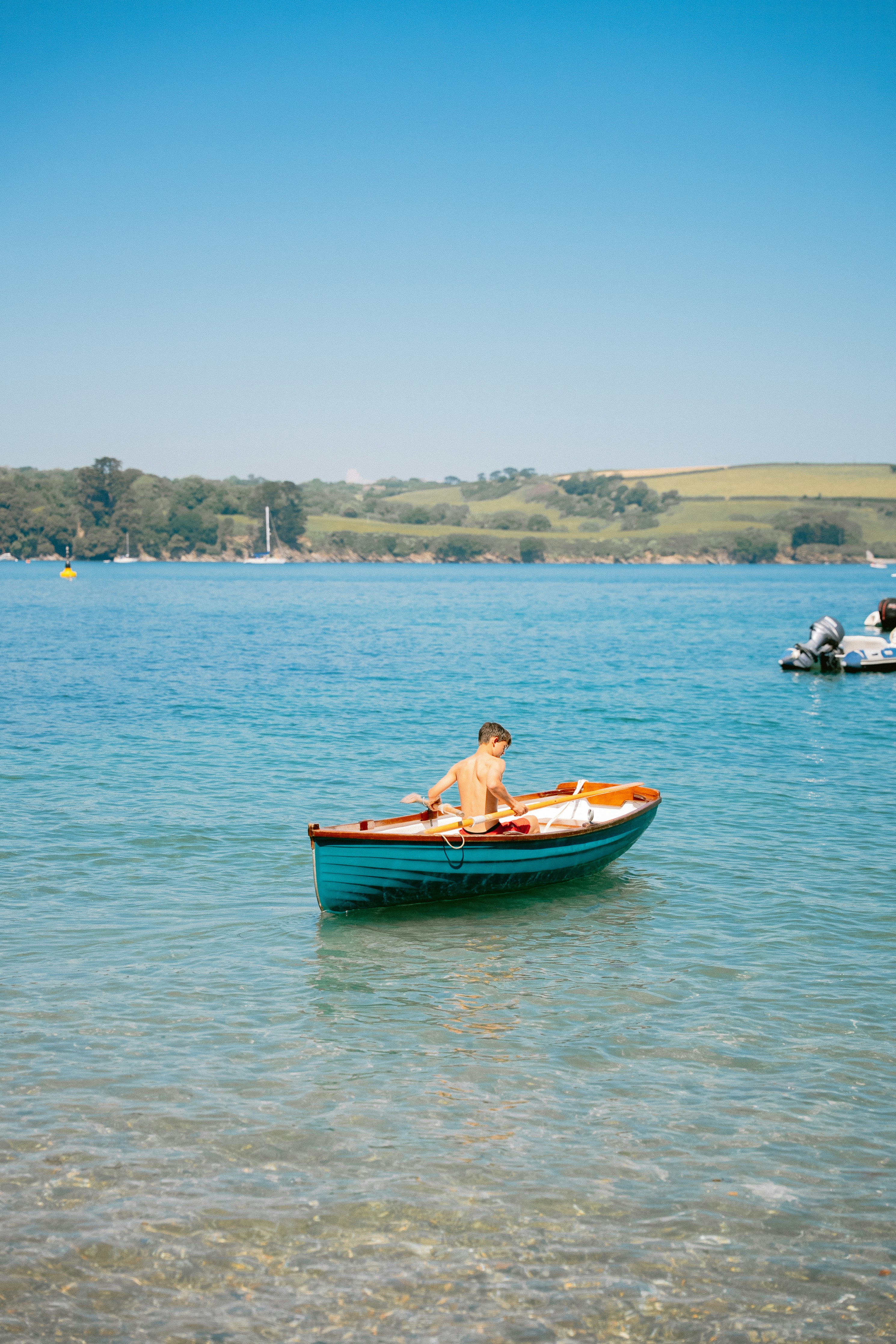 Boat at the Calm Edge: A Child's Rest in Blue Waters