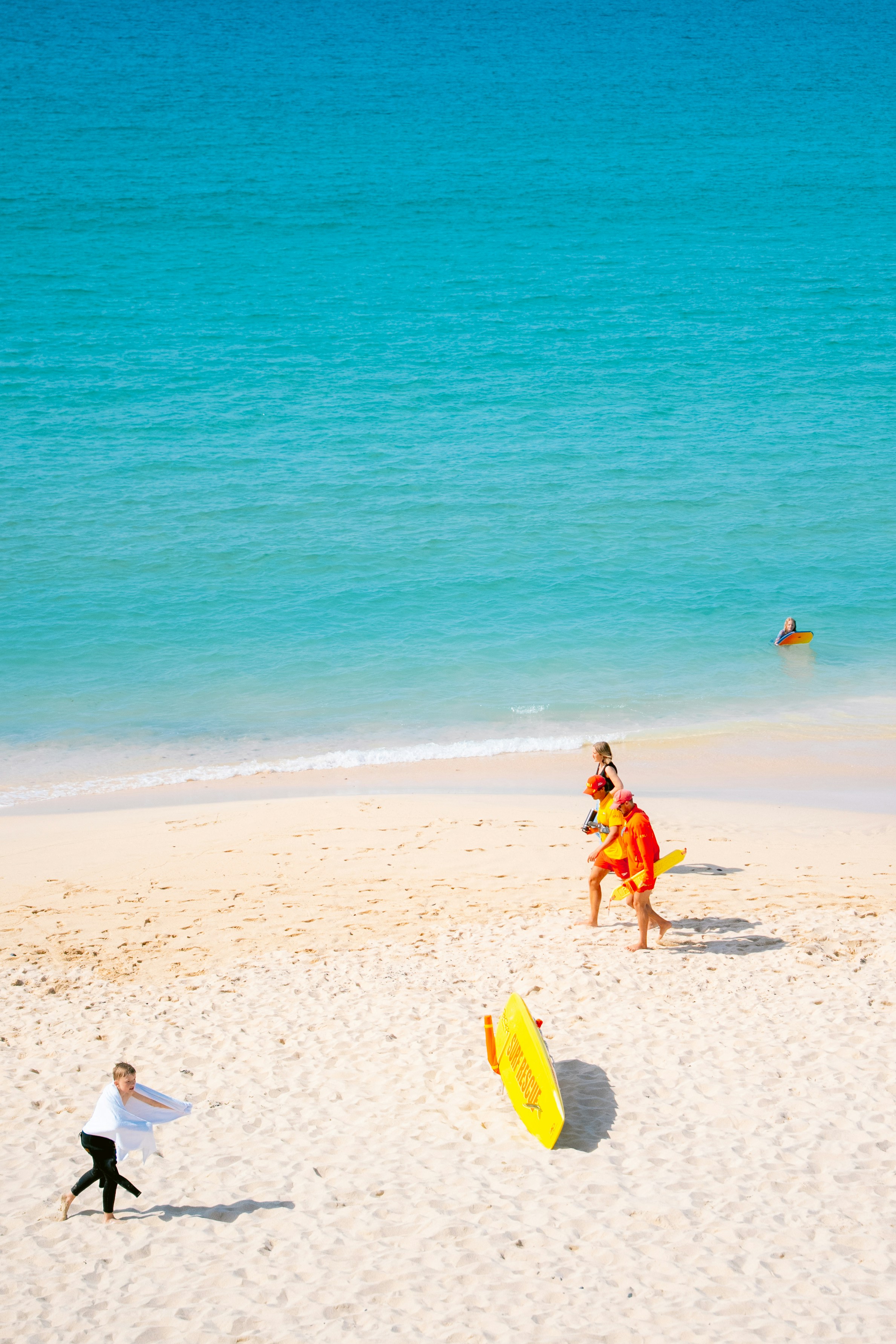 Lifeguards in Orange on a Sunlit Shore