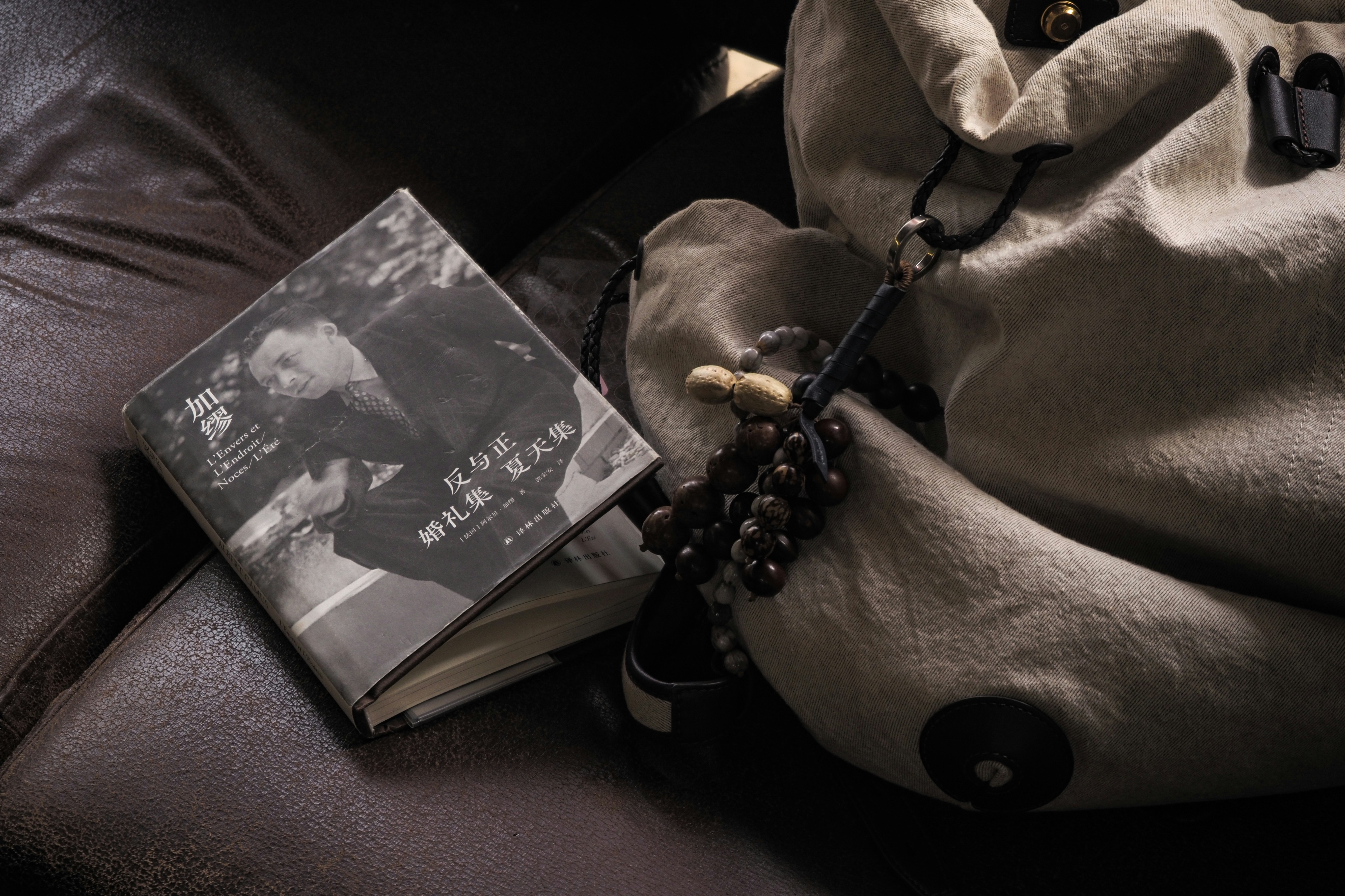 A book and a canvas bag on a dark surface.