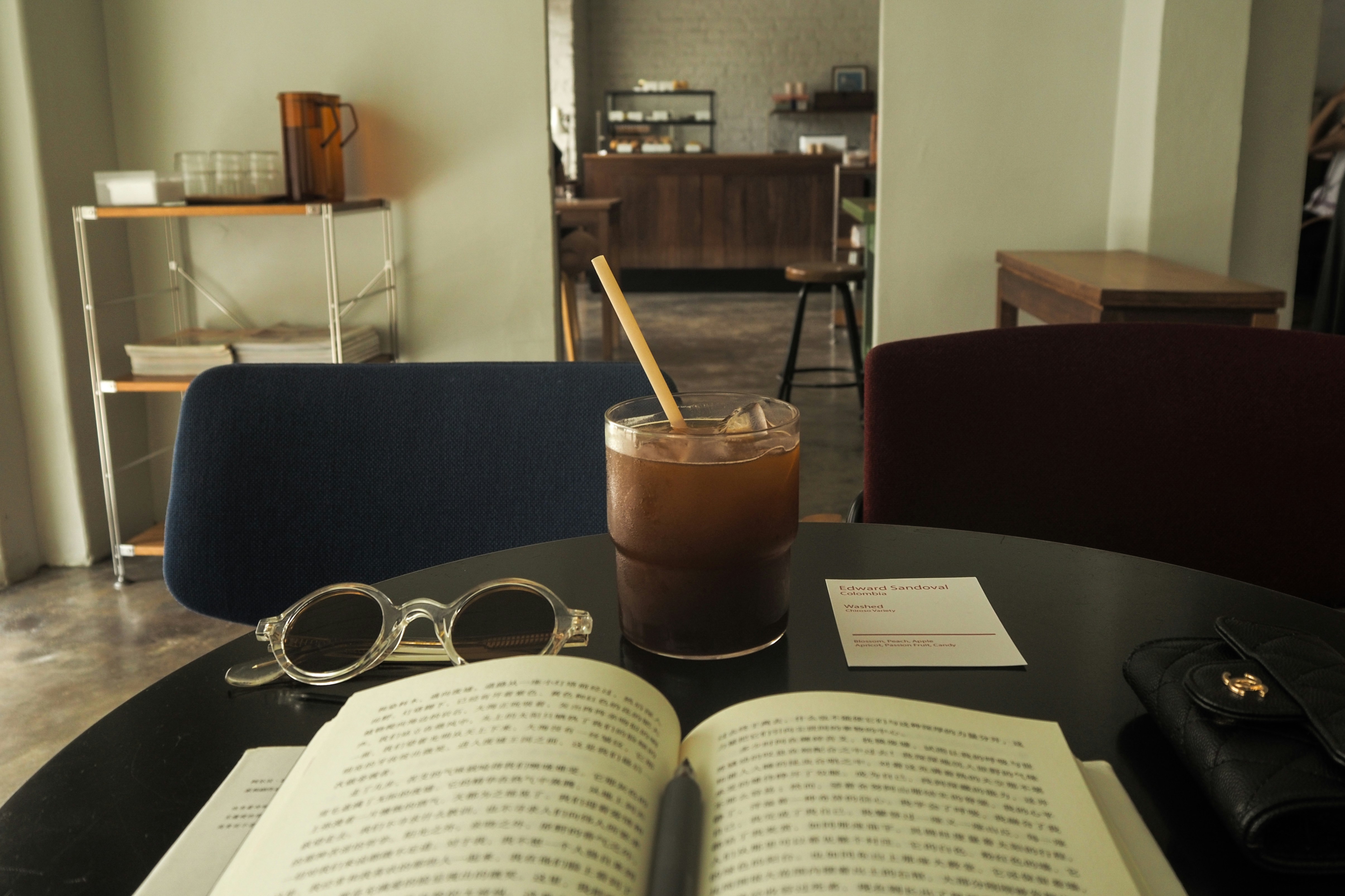 Quiet Focus at a Cozy Café: Reading, Ice Coffee, and Sunglasses
