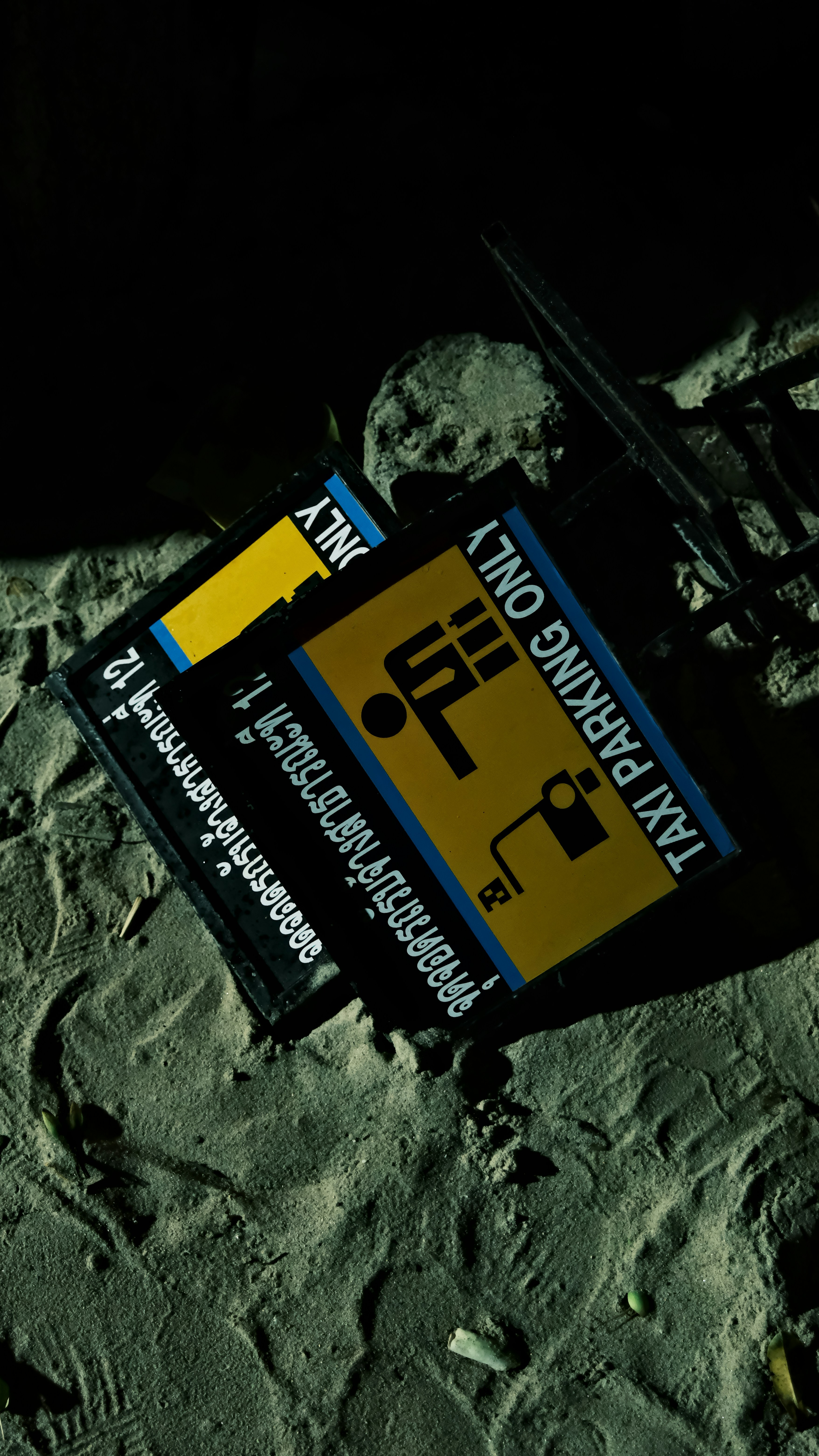 Tilting Warning Sign Half-Buried in Moonlit Sand