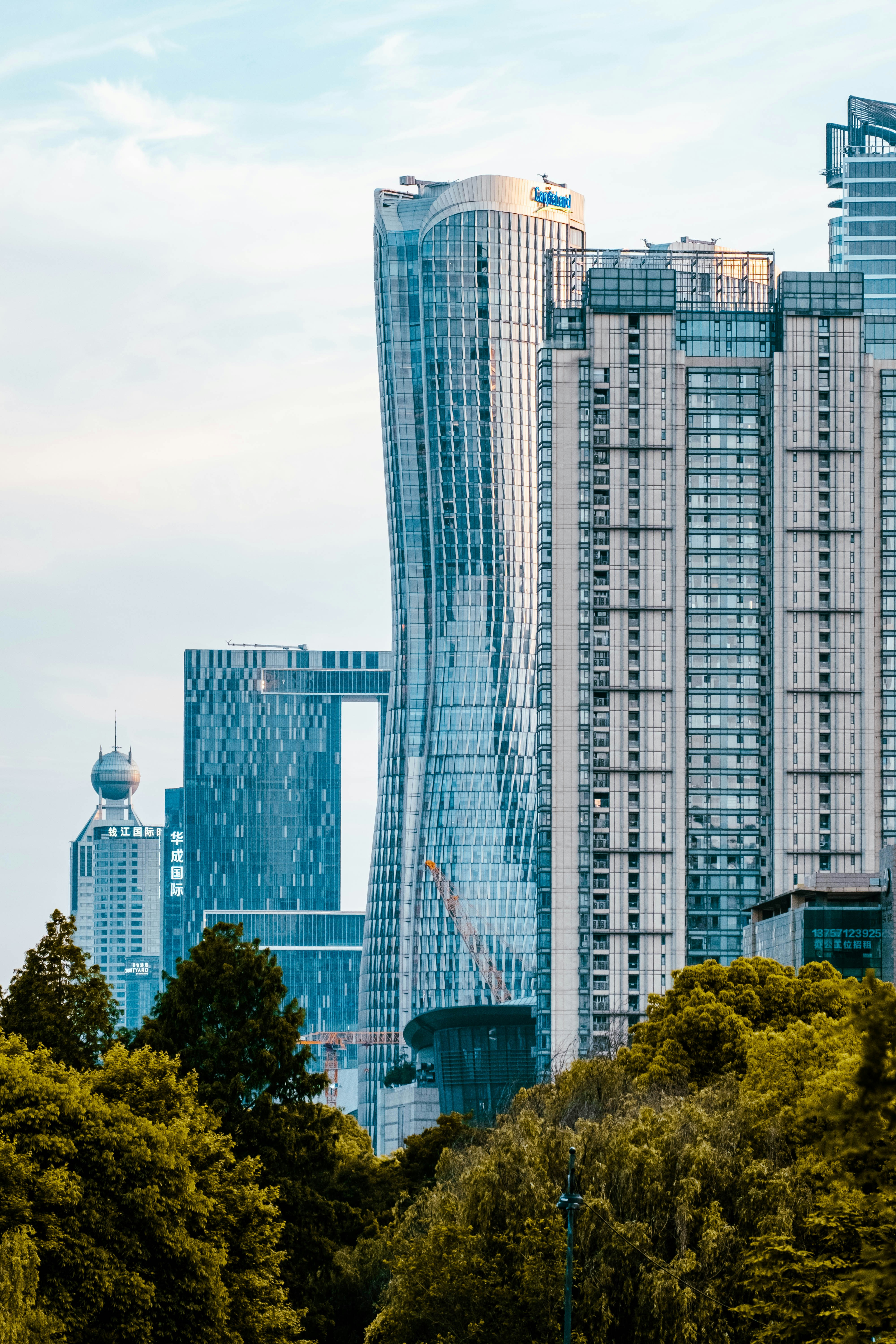 Sinuous Skyscraper Arc Rises Above a Green Corridor