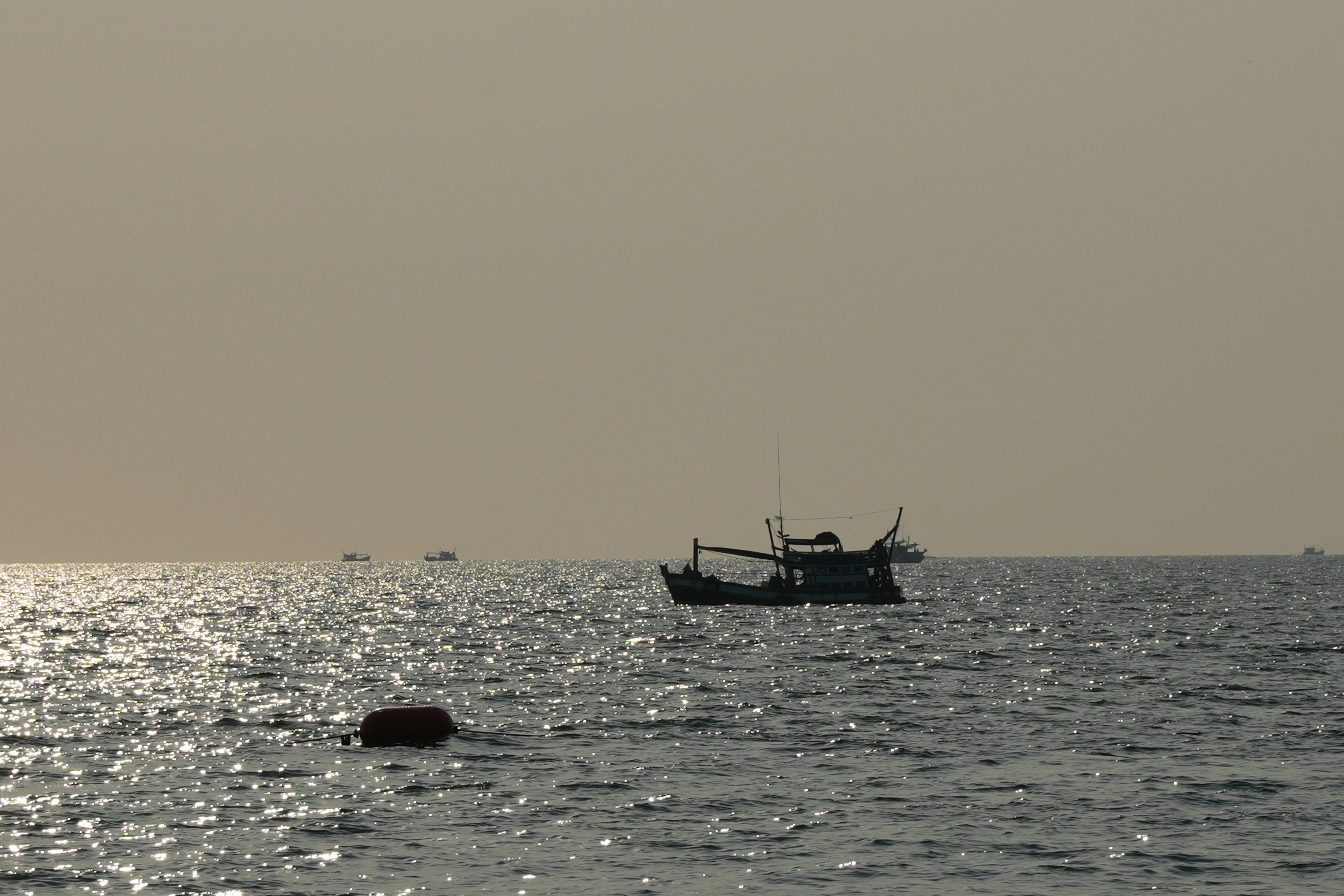 Silhouette at Sundown: A Small Boat on Quiet Seas