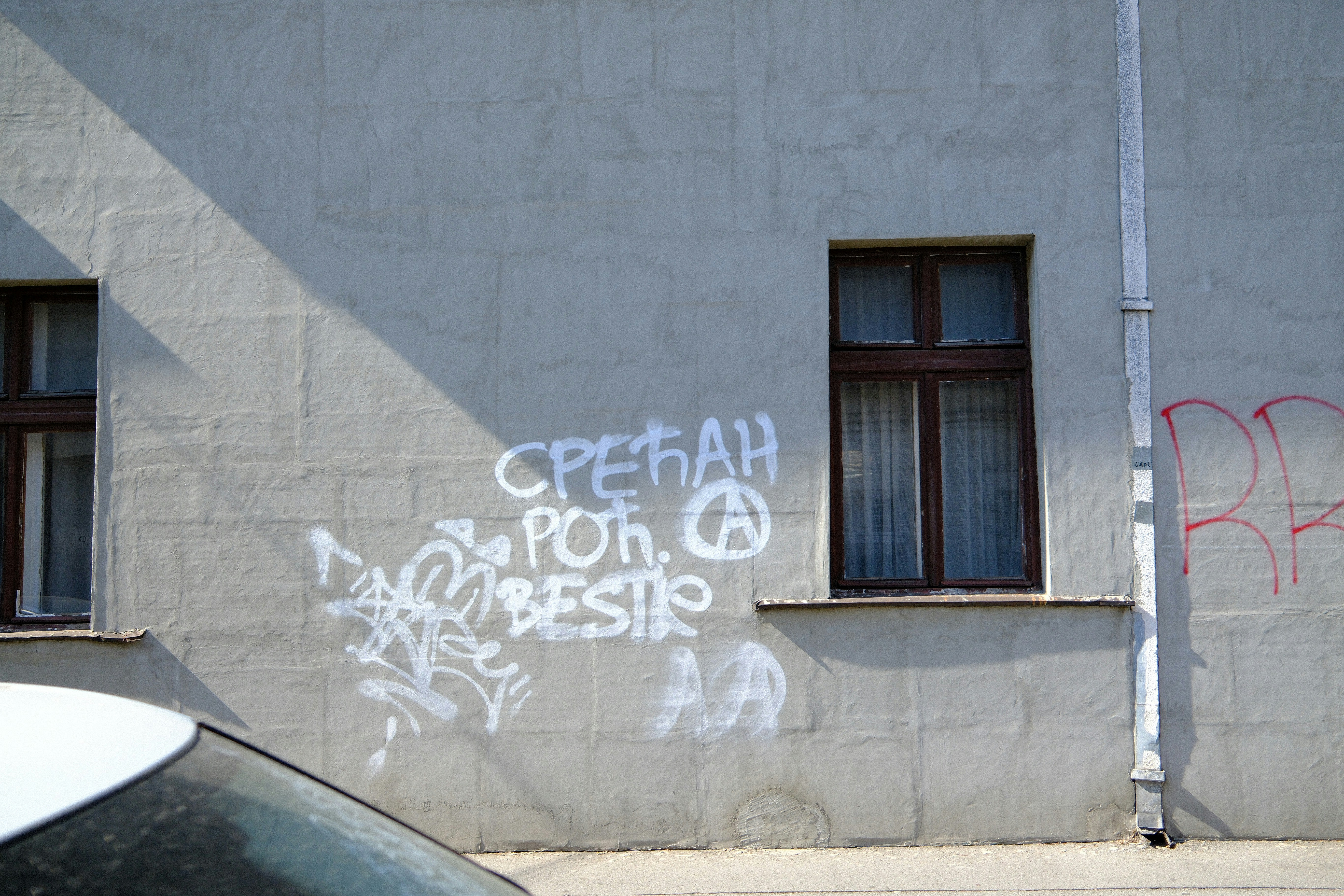Graffiti Canopy: Arching Shadow and Windows on a City Wall