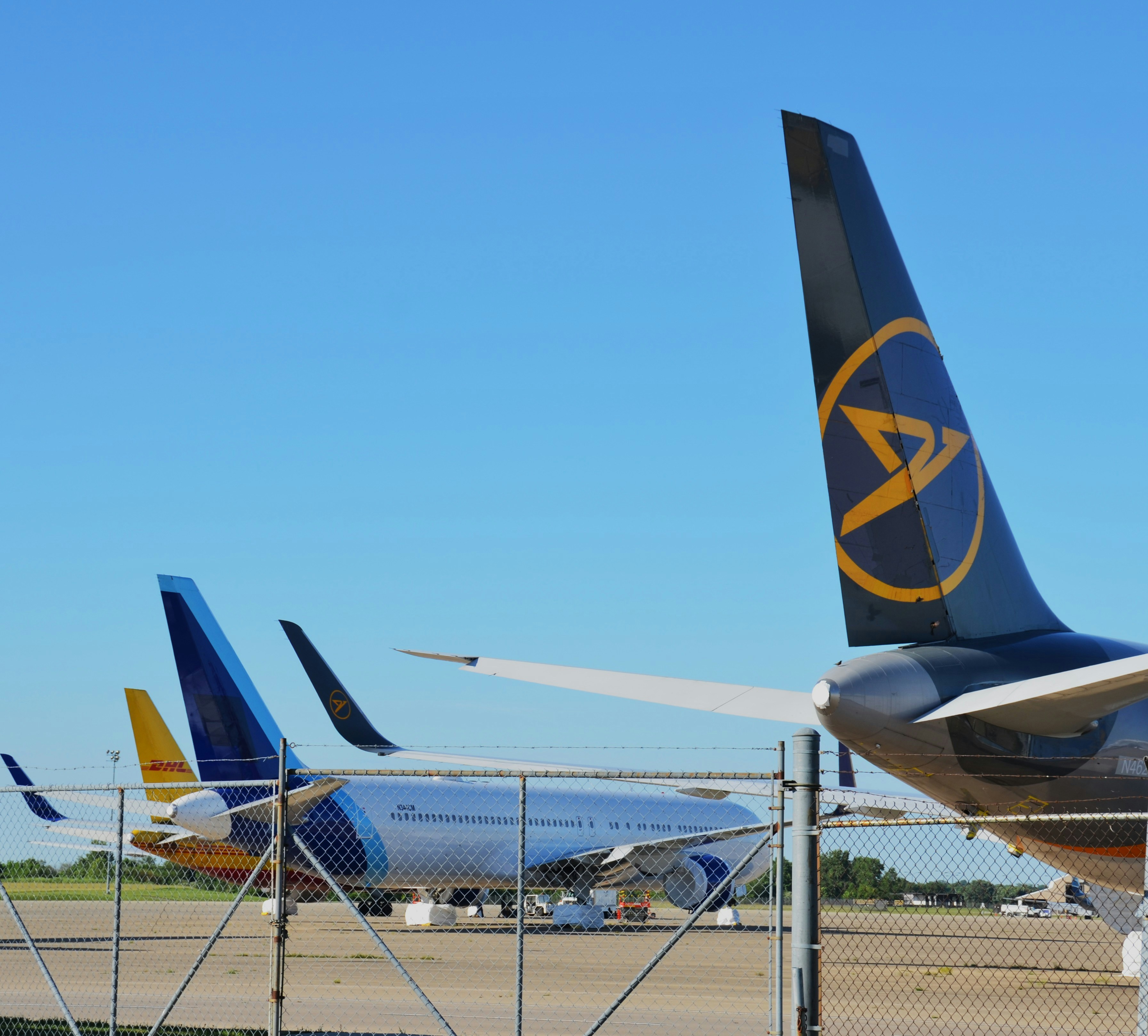 Quiet Tarmac Symphony: Tailfin Lines and Sunlit Wings