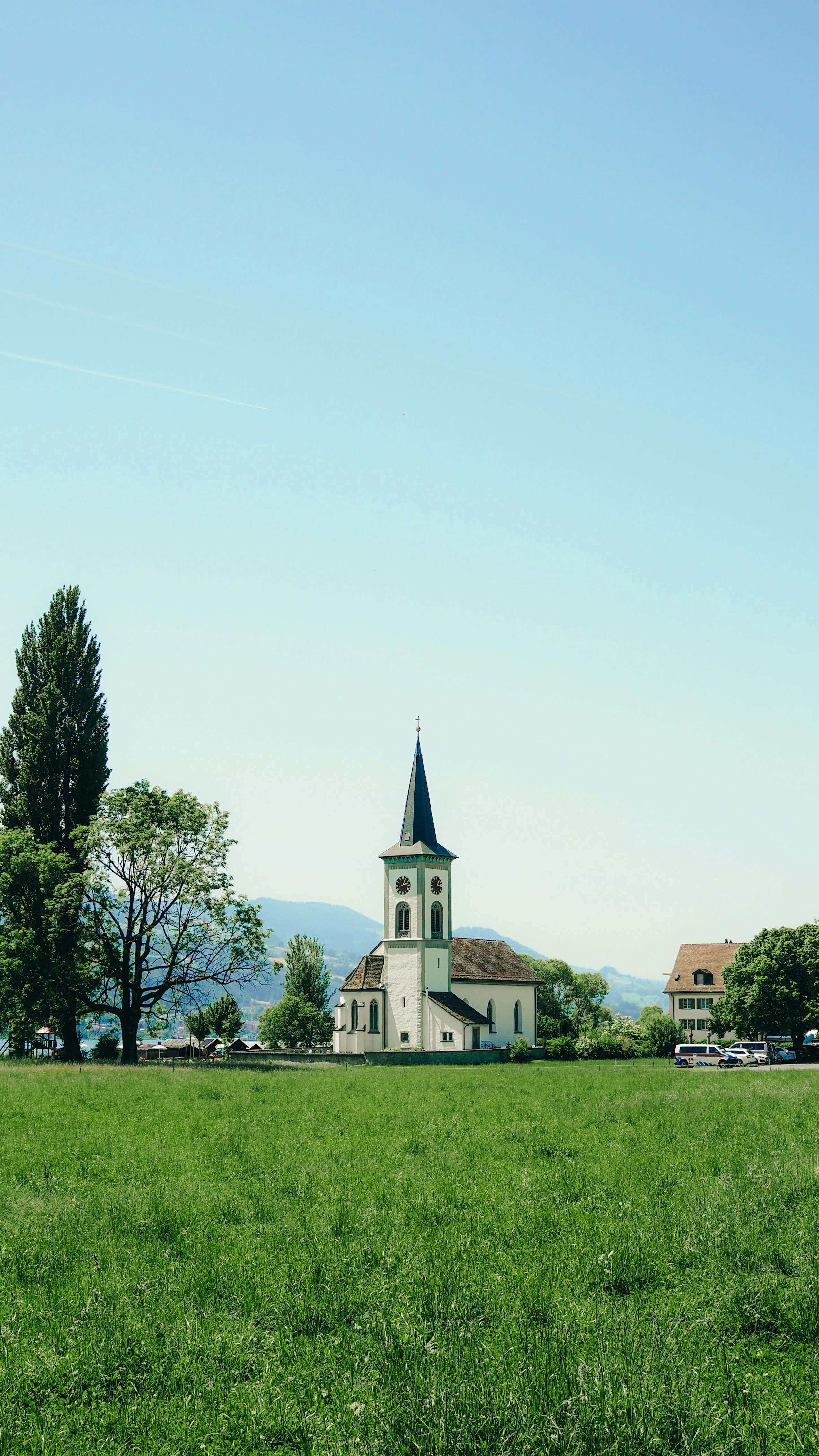 Village Church Rising Above the Green Field