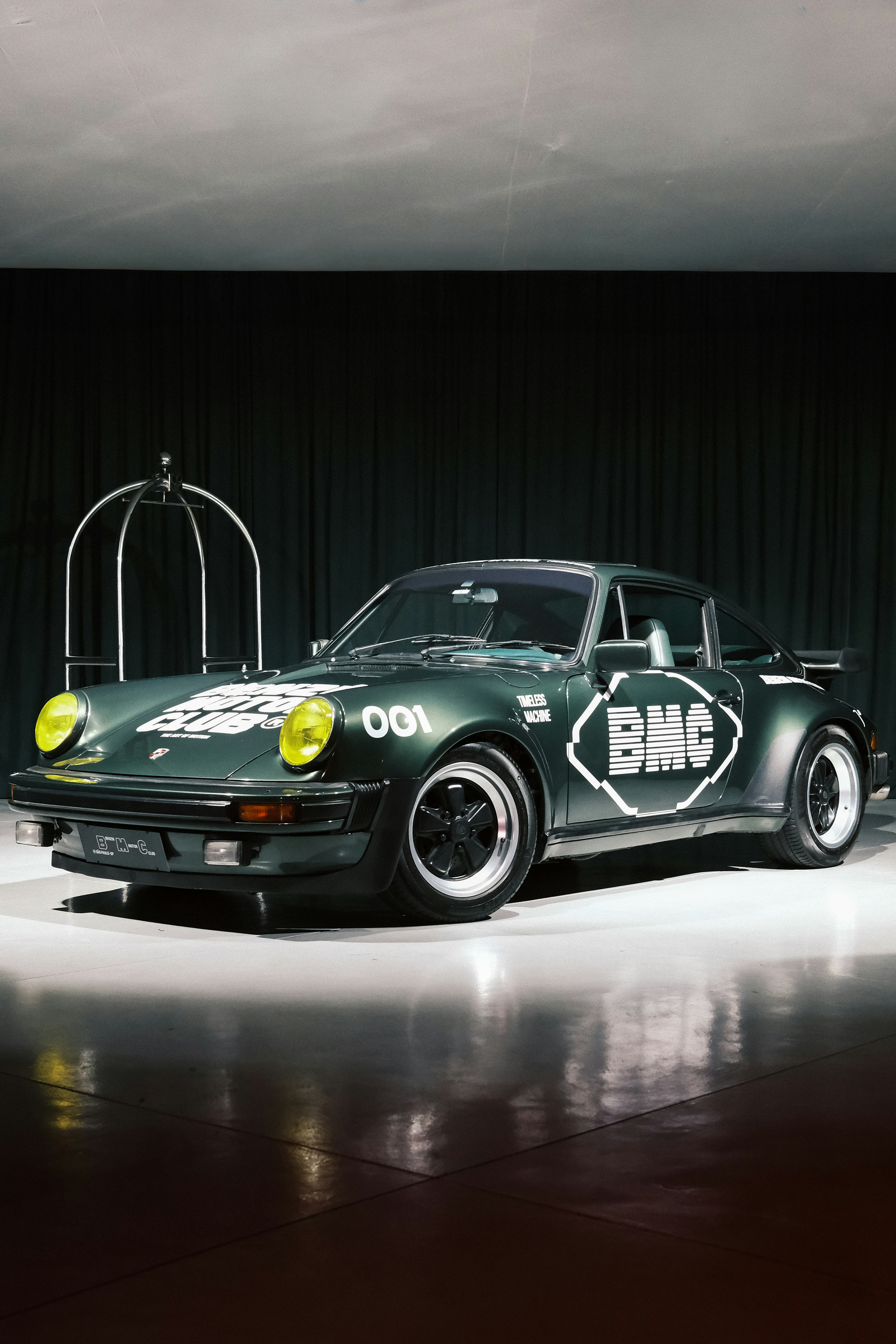 Green Porsche in a spotlight, vintage livery and bold logo