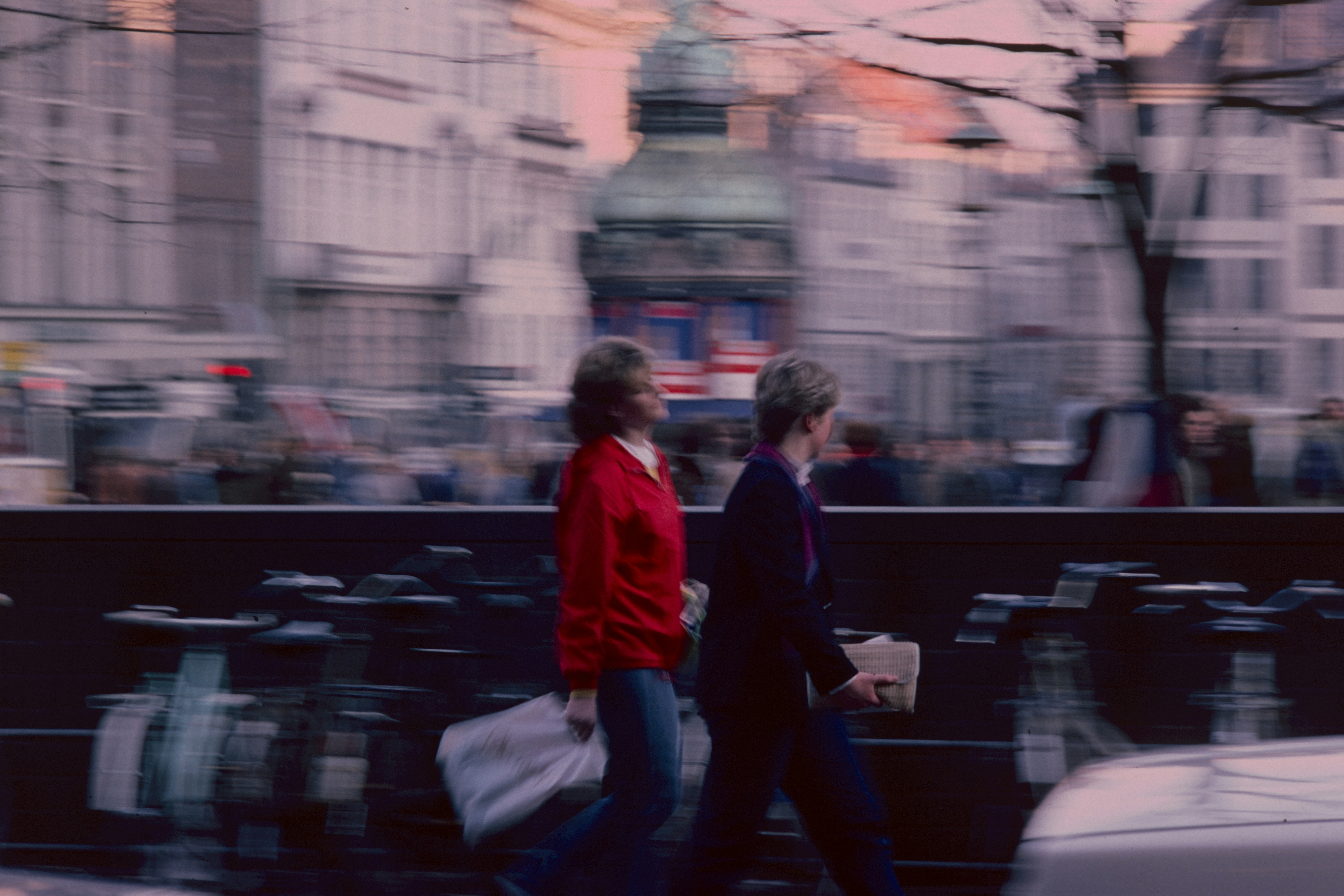 Couple in motion: blurred city stroll past a Waiting Monument