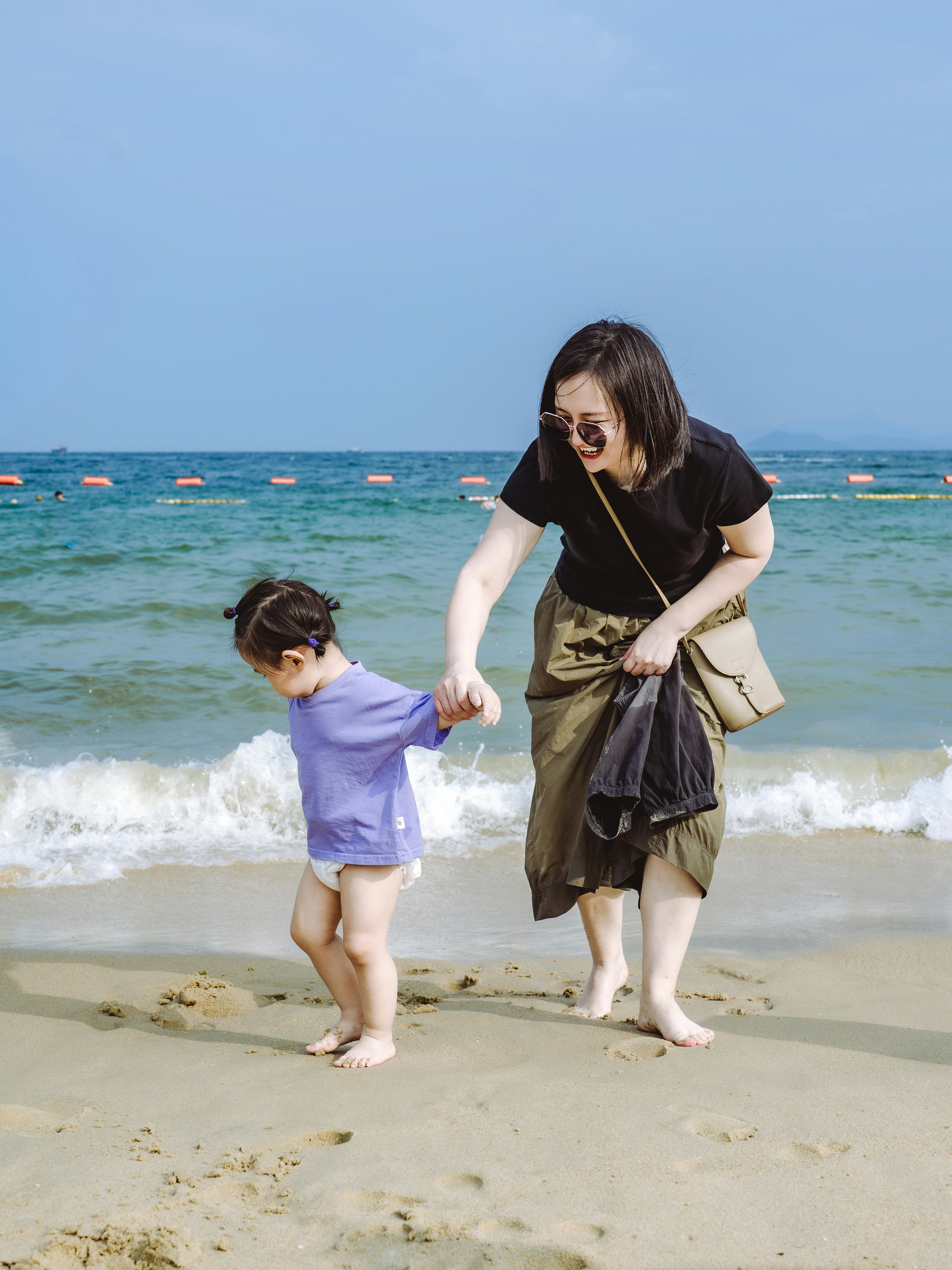 Carefree Steps: A Mother and Child Share a Walk Along the Shore