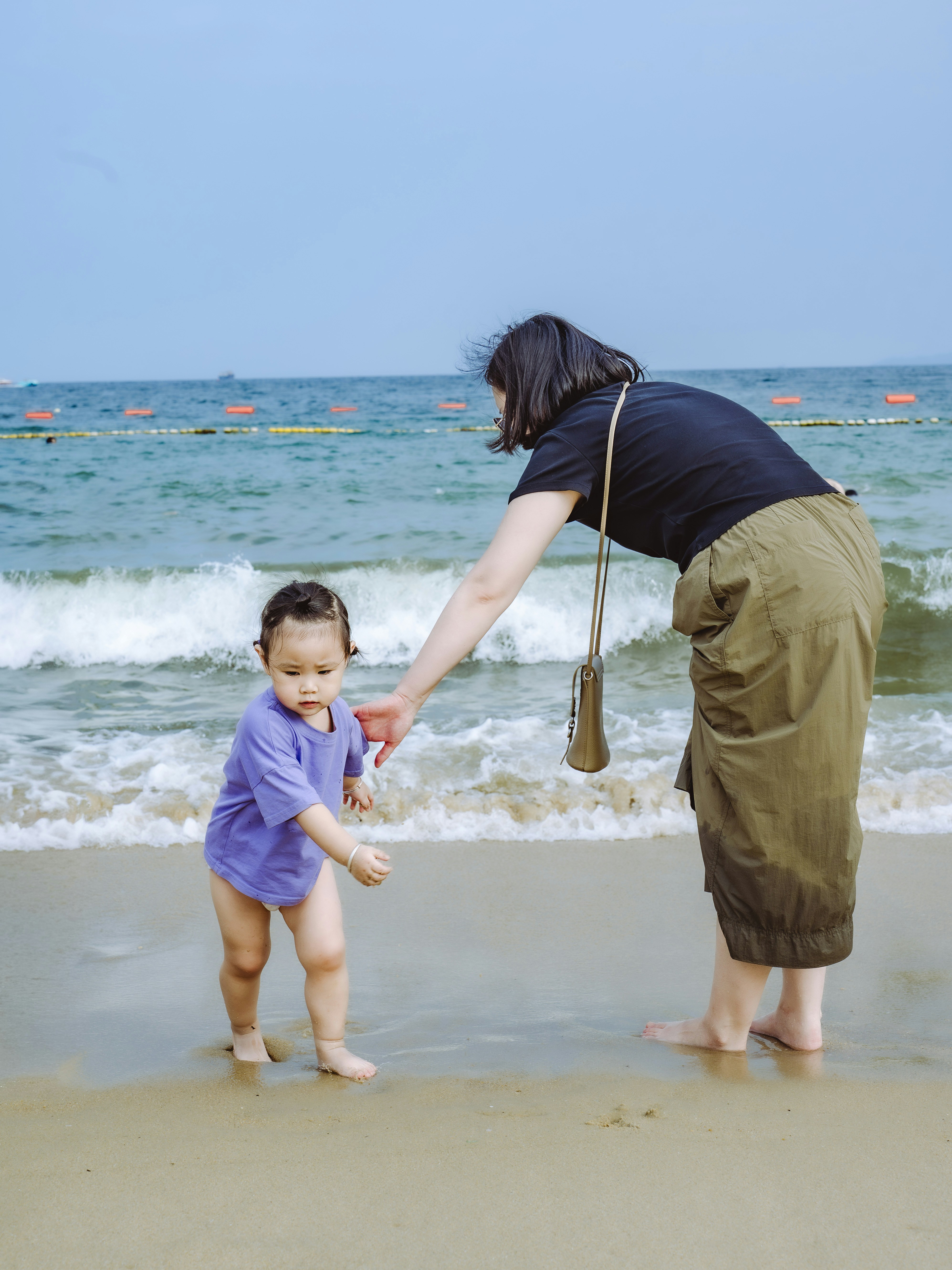 Guiding Hands: A Caregiver Helps a Little One Discover the Sea