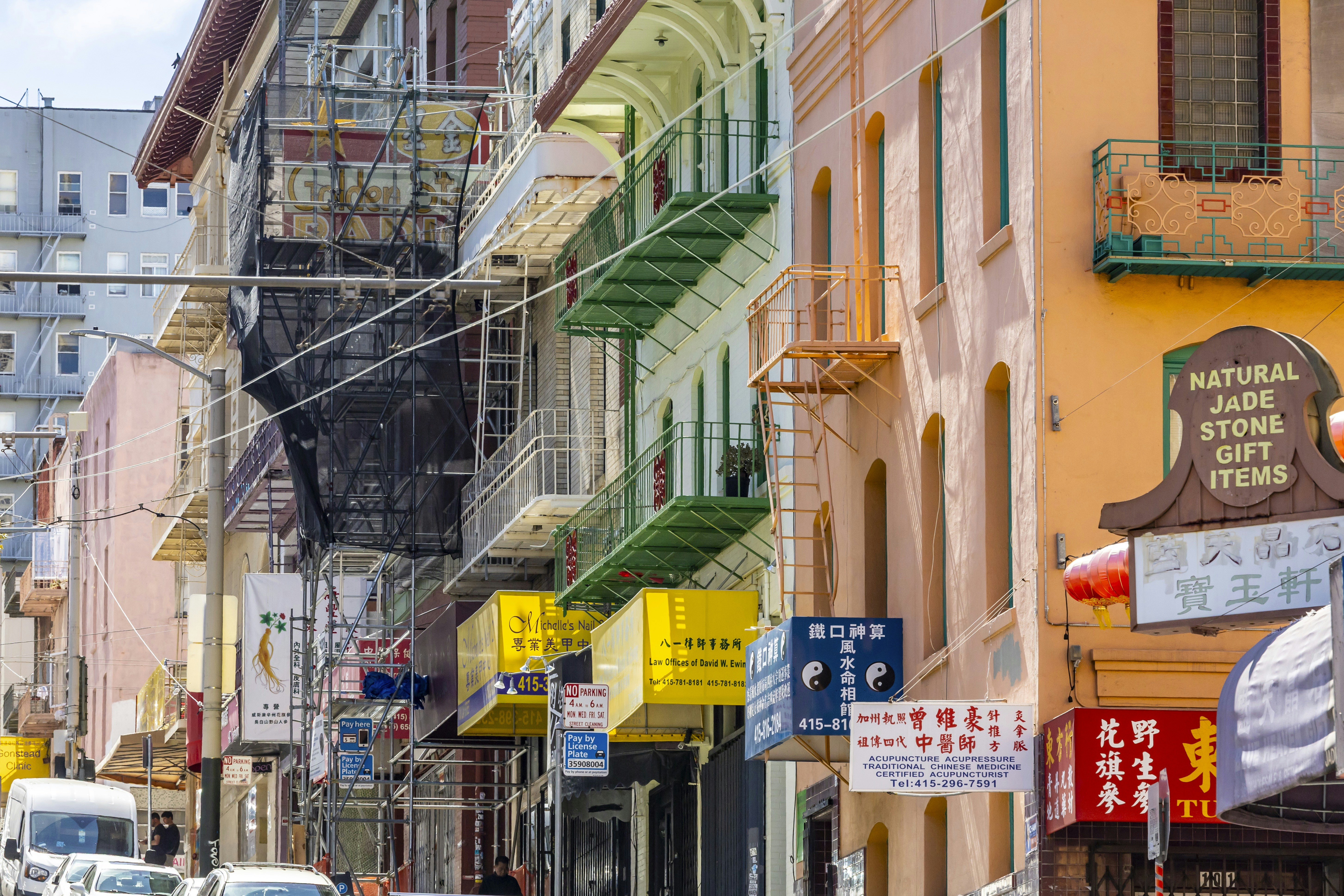 Colorful buildings and signs line a bustling street in chinatown.