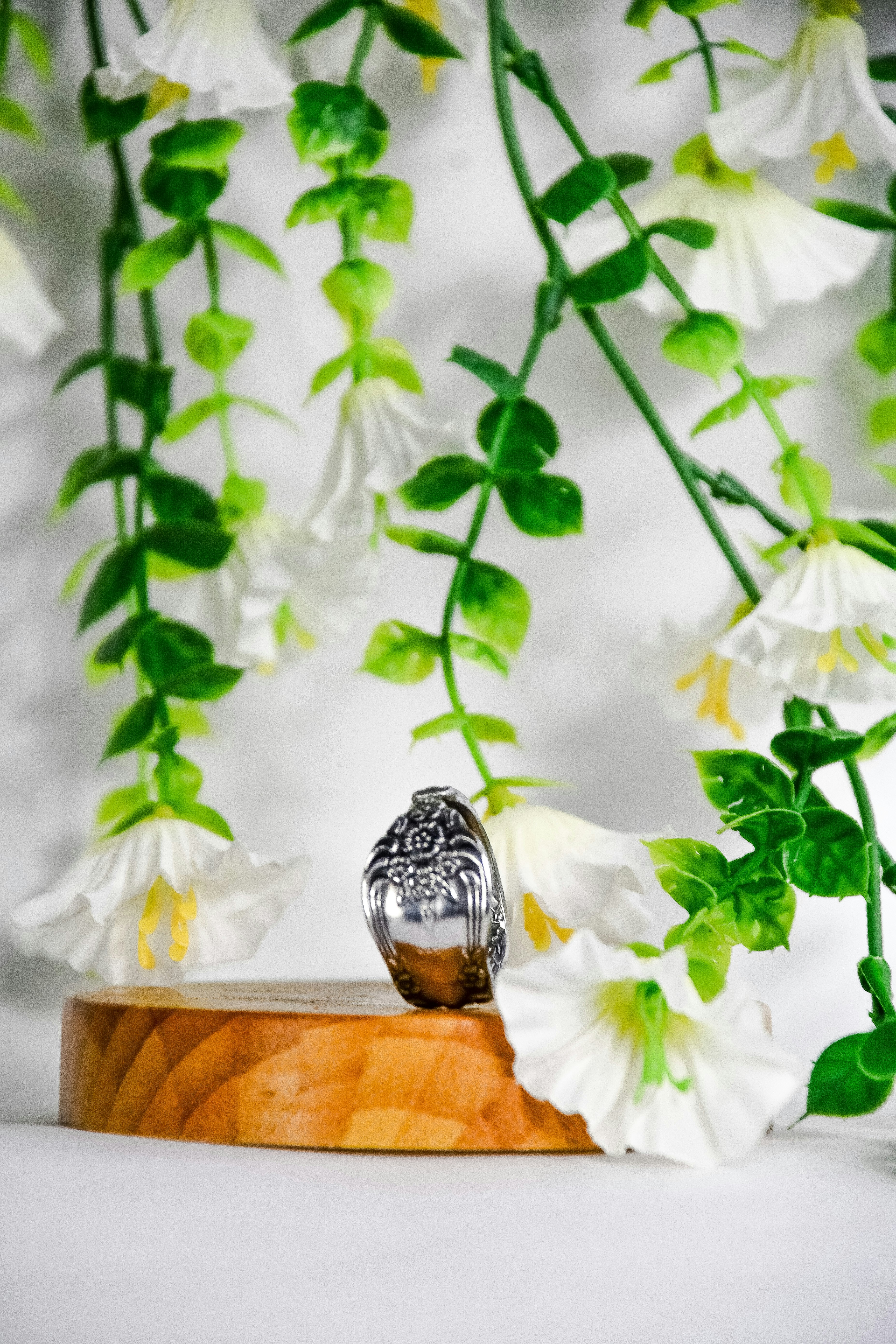 Petite Jewelry on a Carved Wood Stage Amid White Bells
