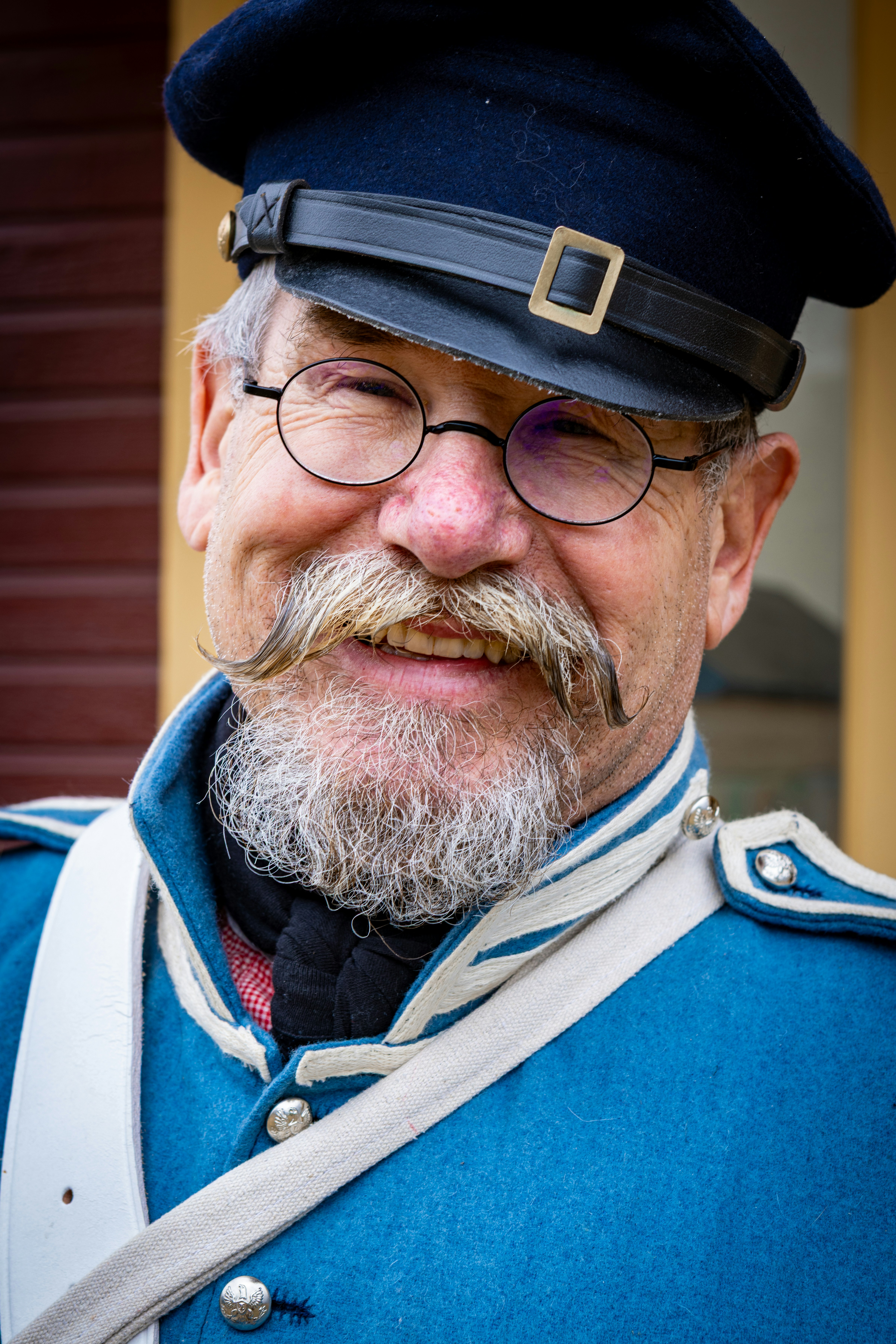 Bandleader in blue: a warm smile under a vintage military cap