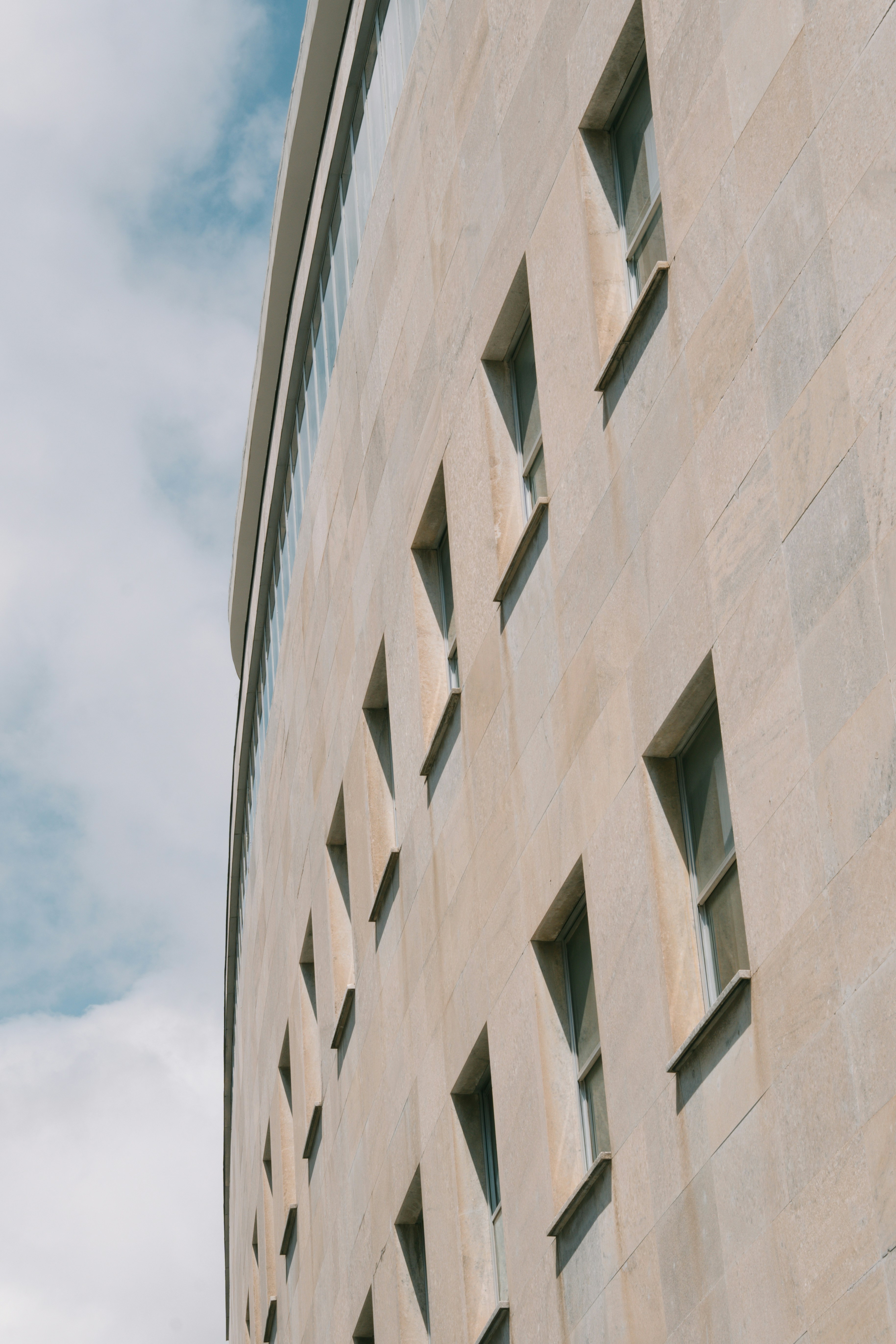 Curved Facade Echoes Light and Windows