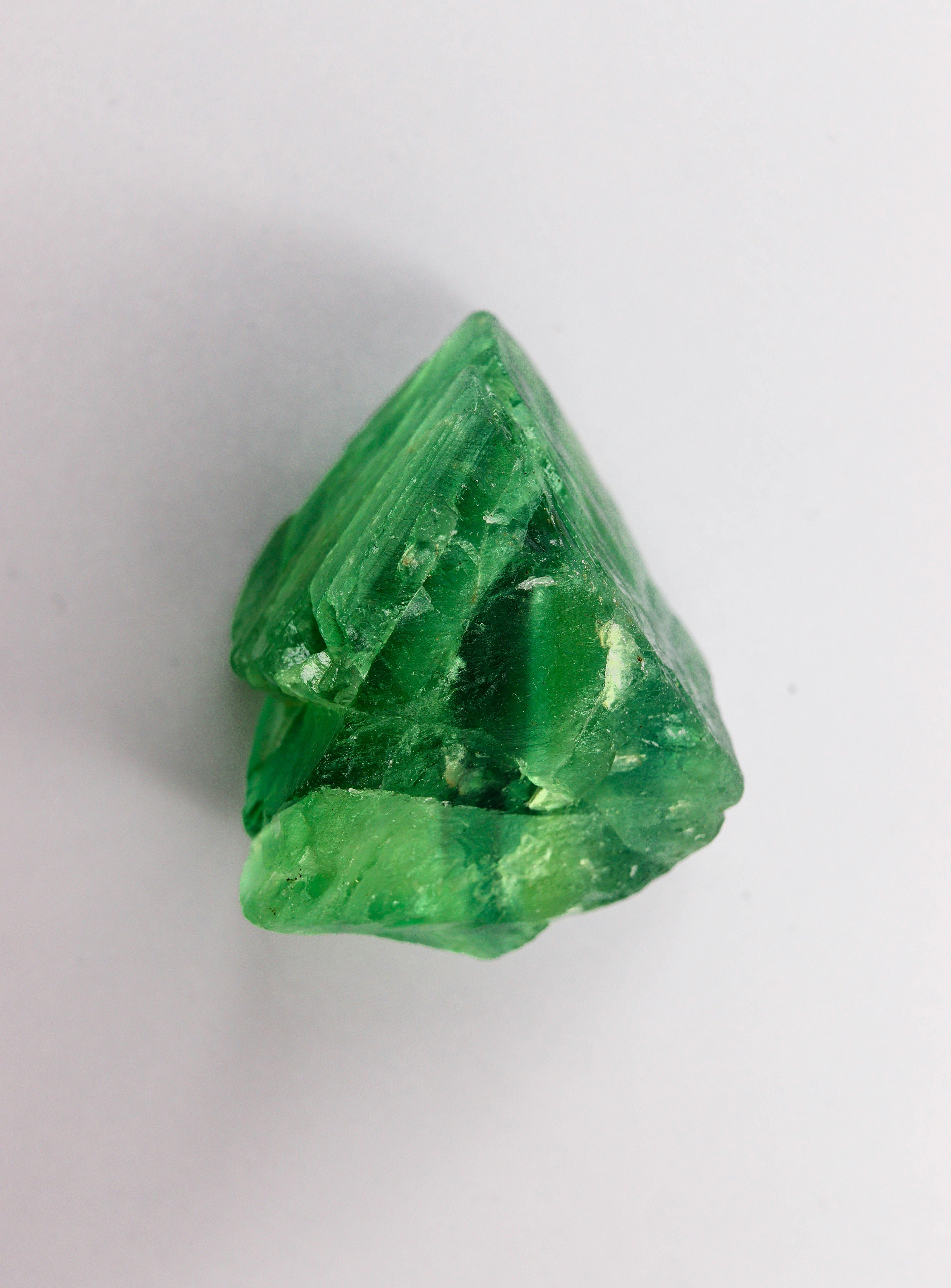 A rough green crystalline rock on a white background.