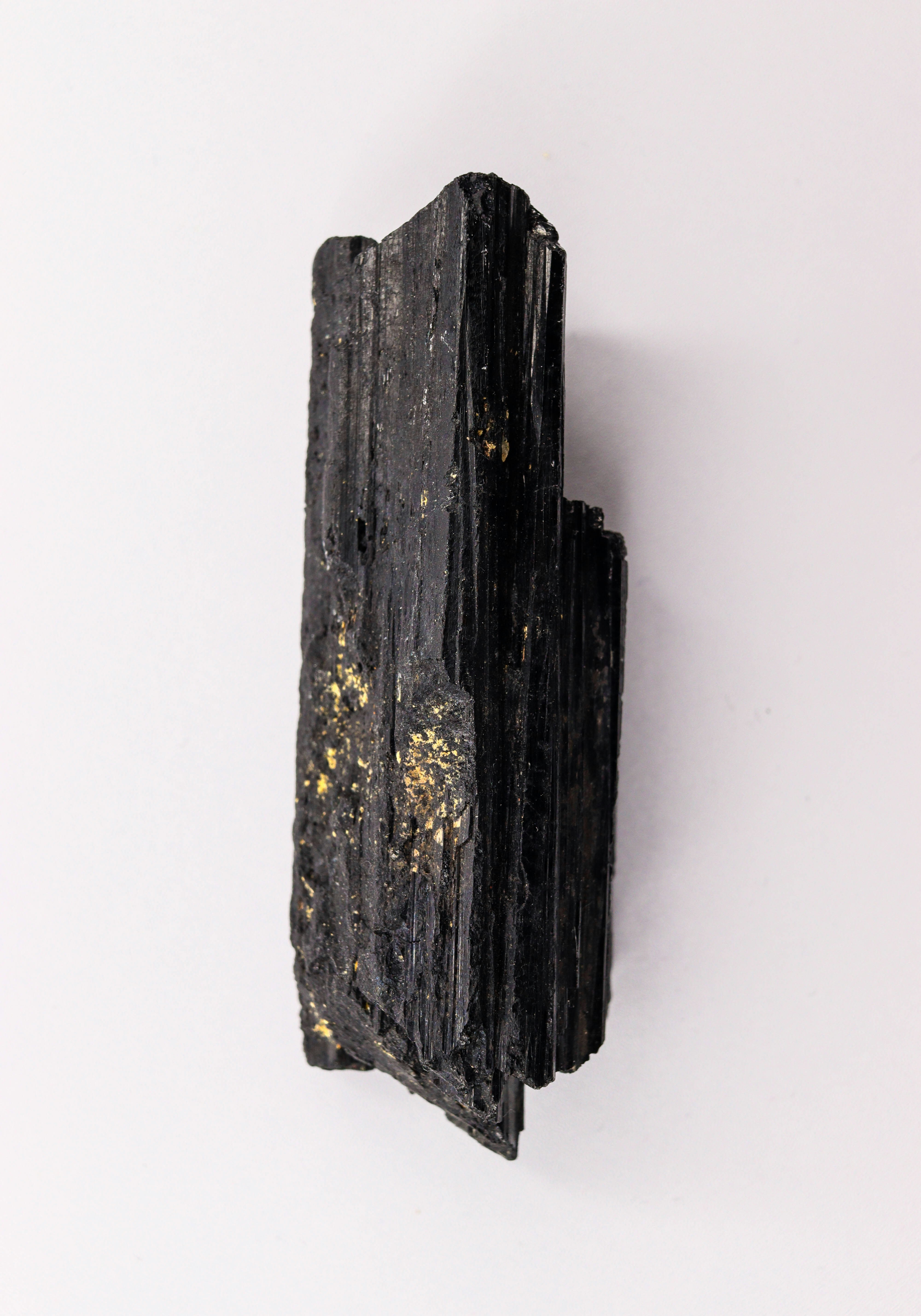Black tourmaline crystal with golden inclusions.