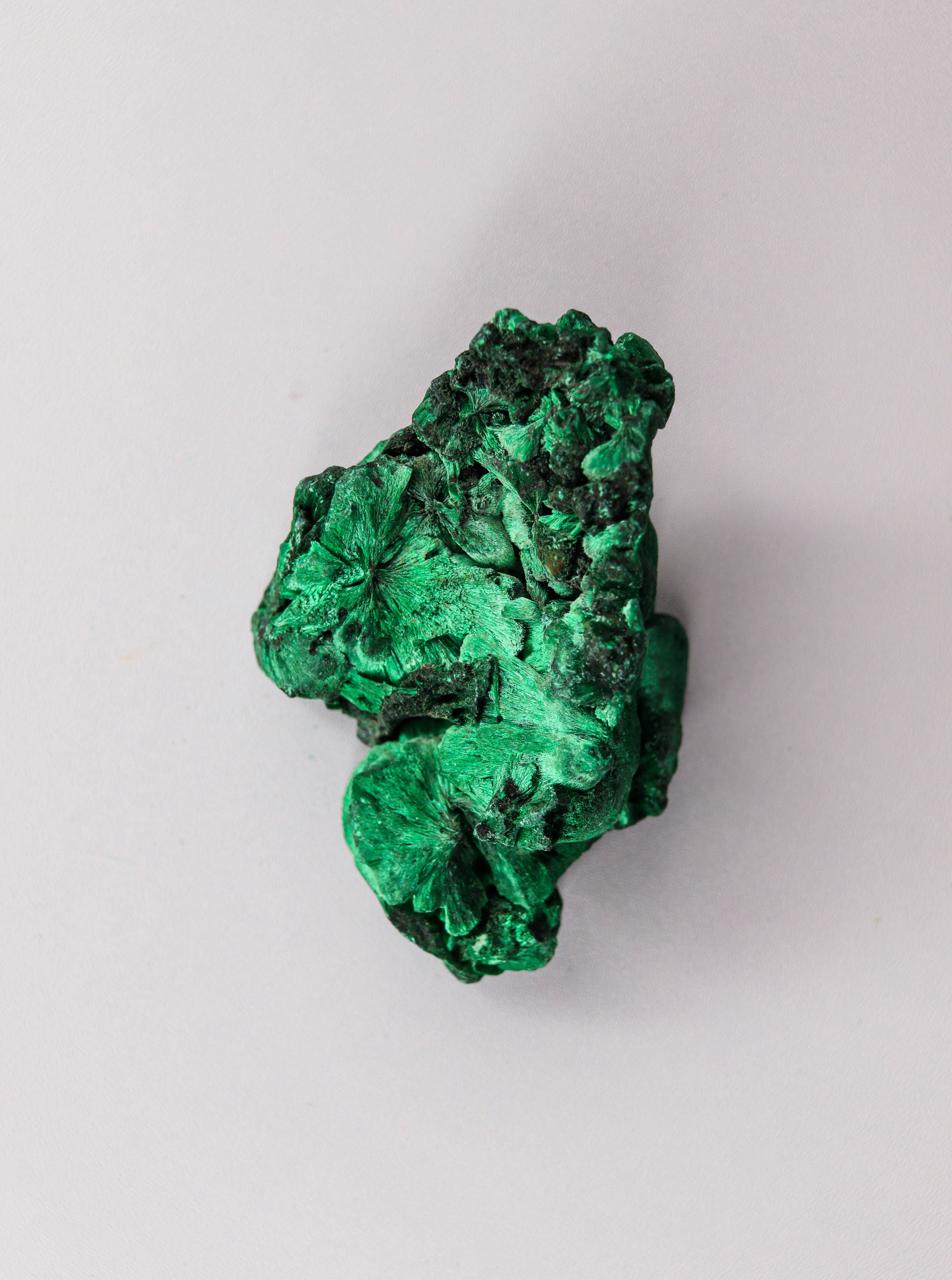 Emerald Hunk: a vivid green mineral fragment on pale backdrop