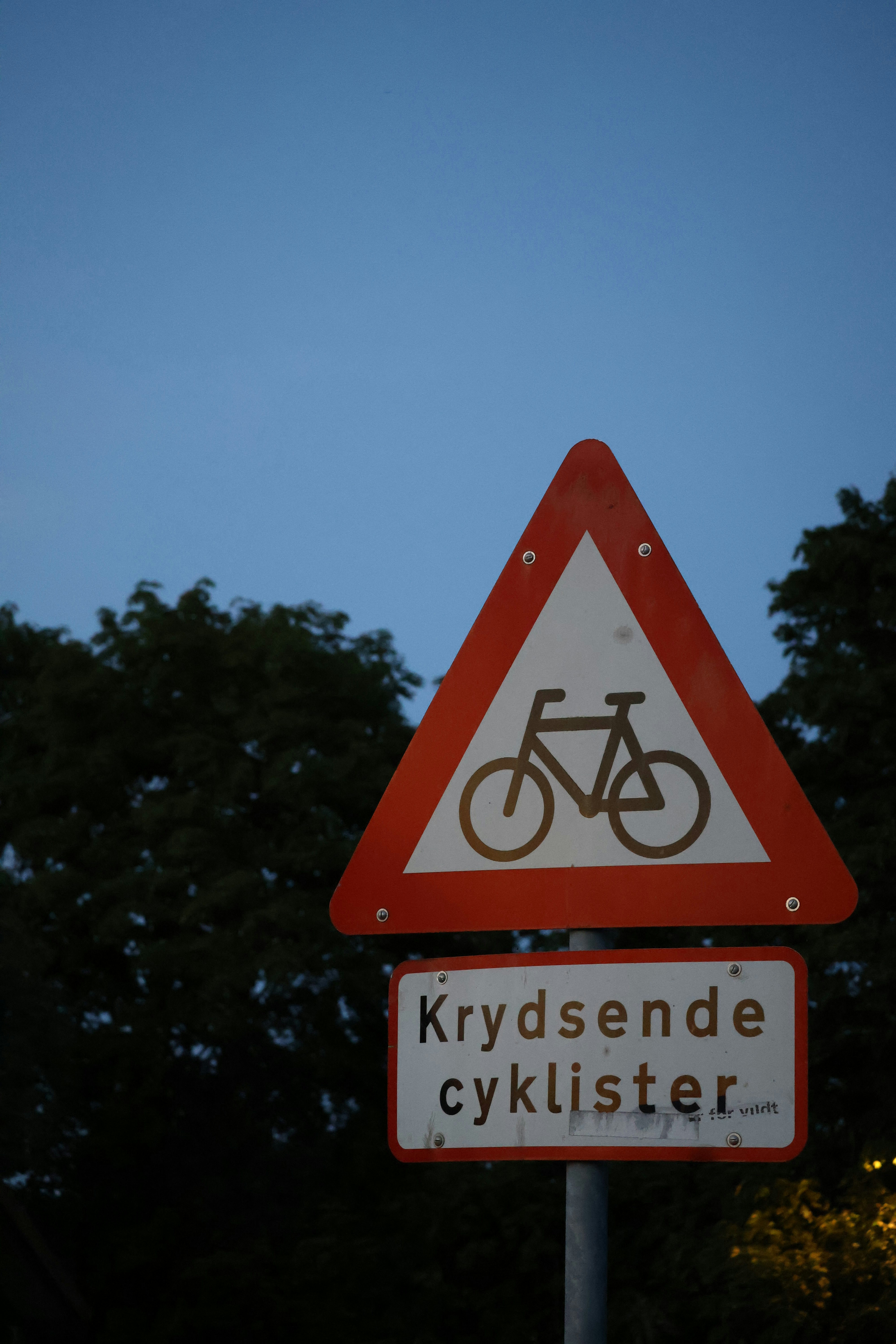 Danish warning sign for crossing cyclists at dusk.