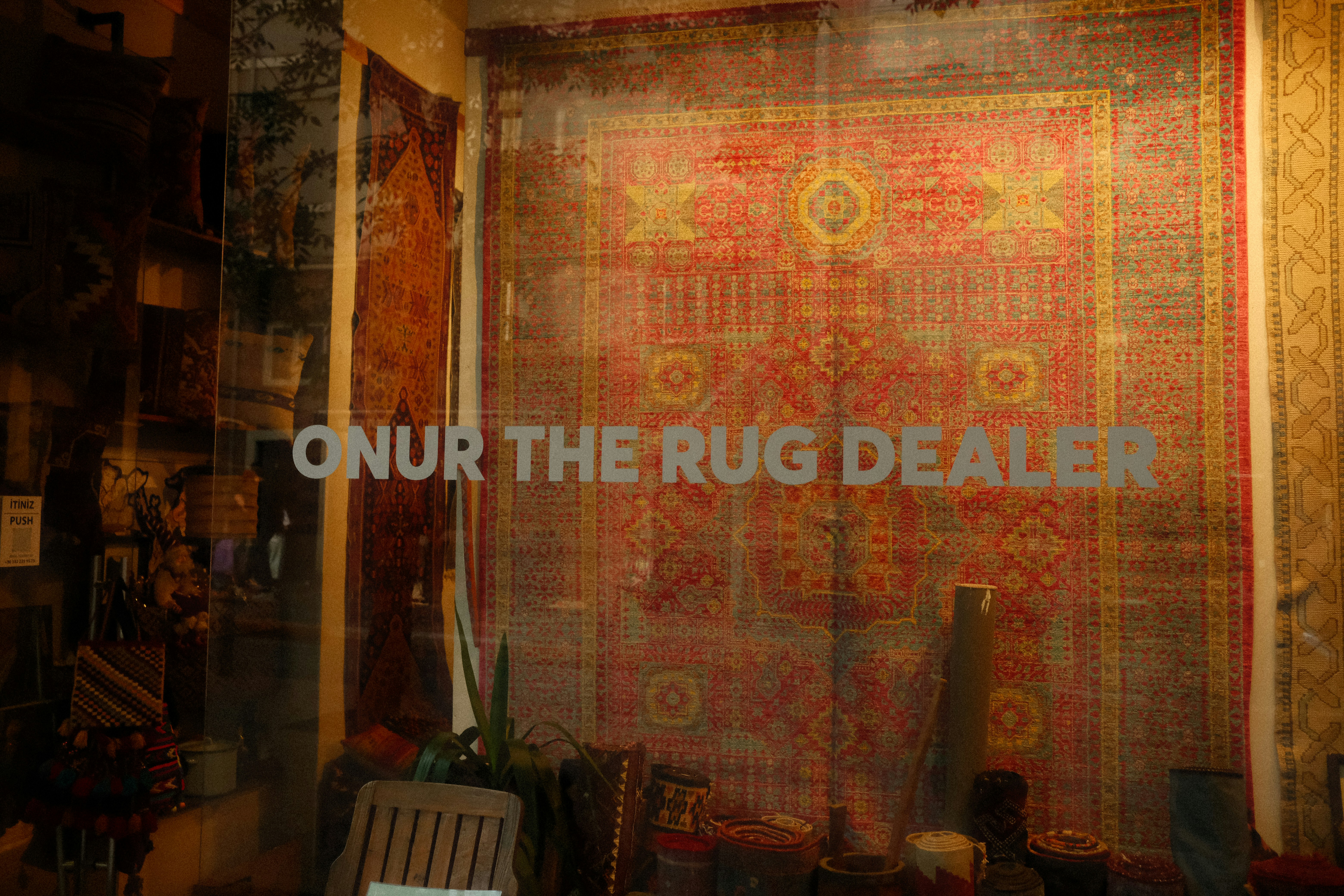  storefront rug world: a glass storefront reveals a patterned tapestry inside