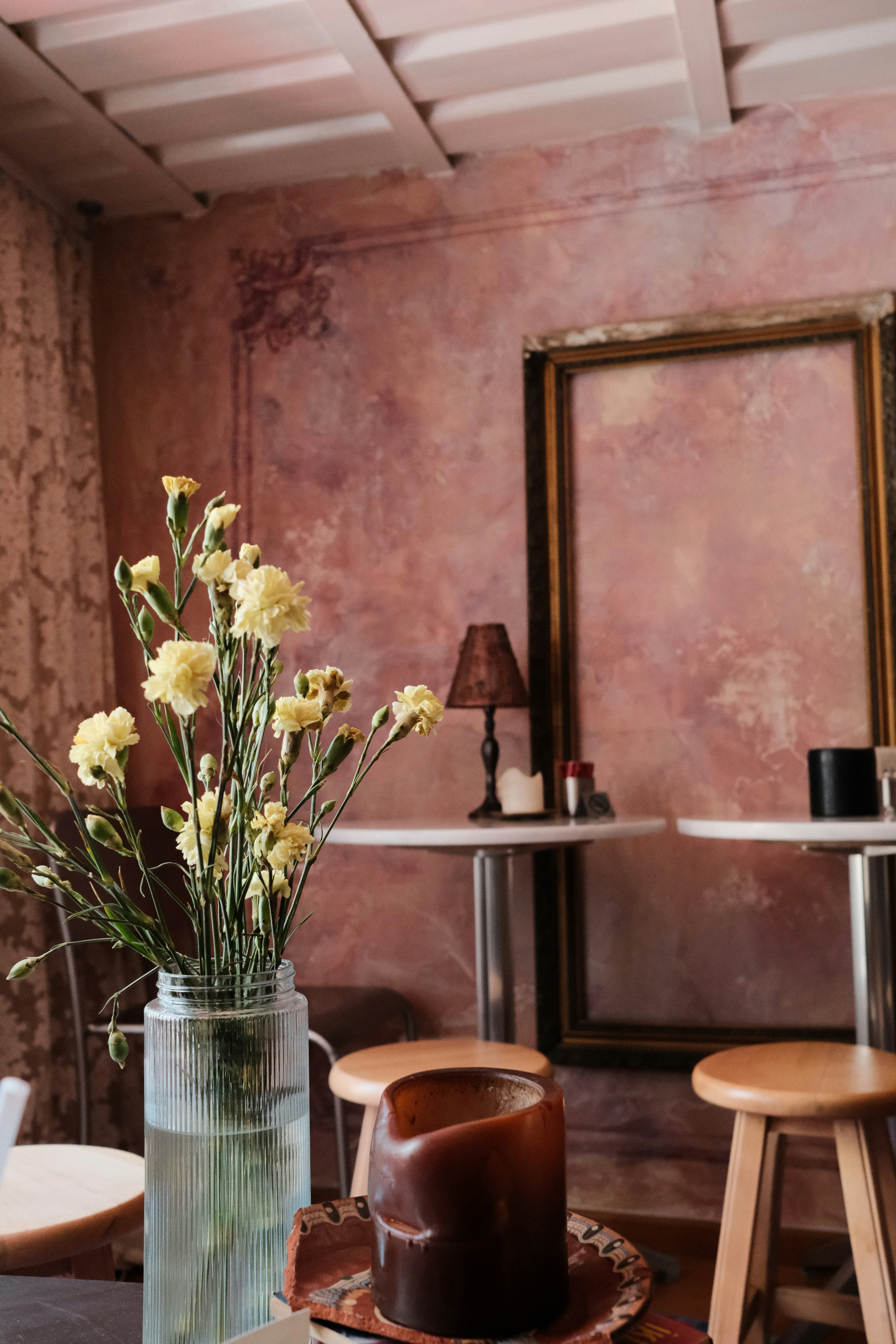 Yellow flowers and a candle in a cozy cafe interior.