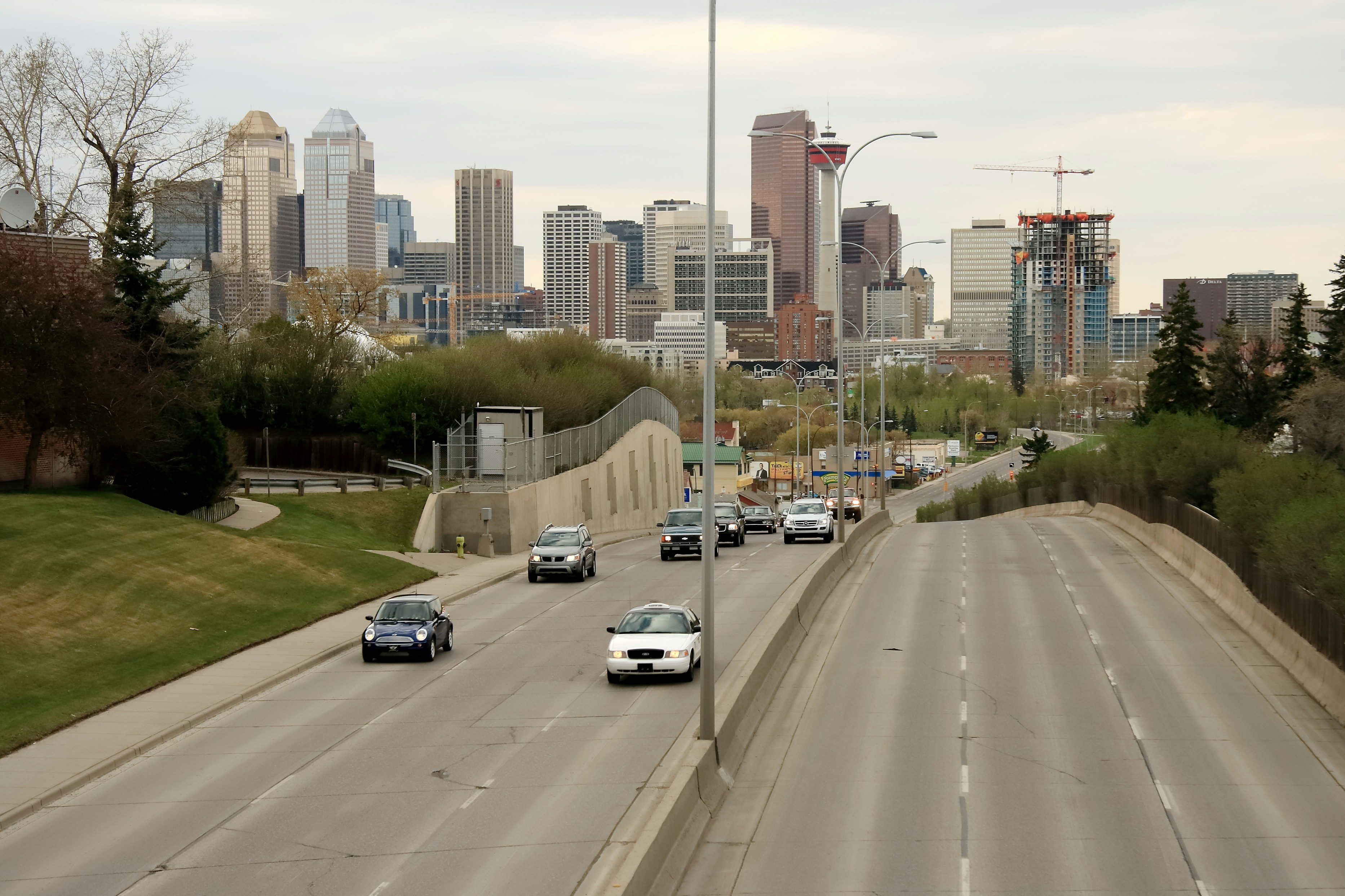 Urban Ascent: Cars Move Through a Concrete Ribbon Toward a Skyline