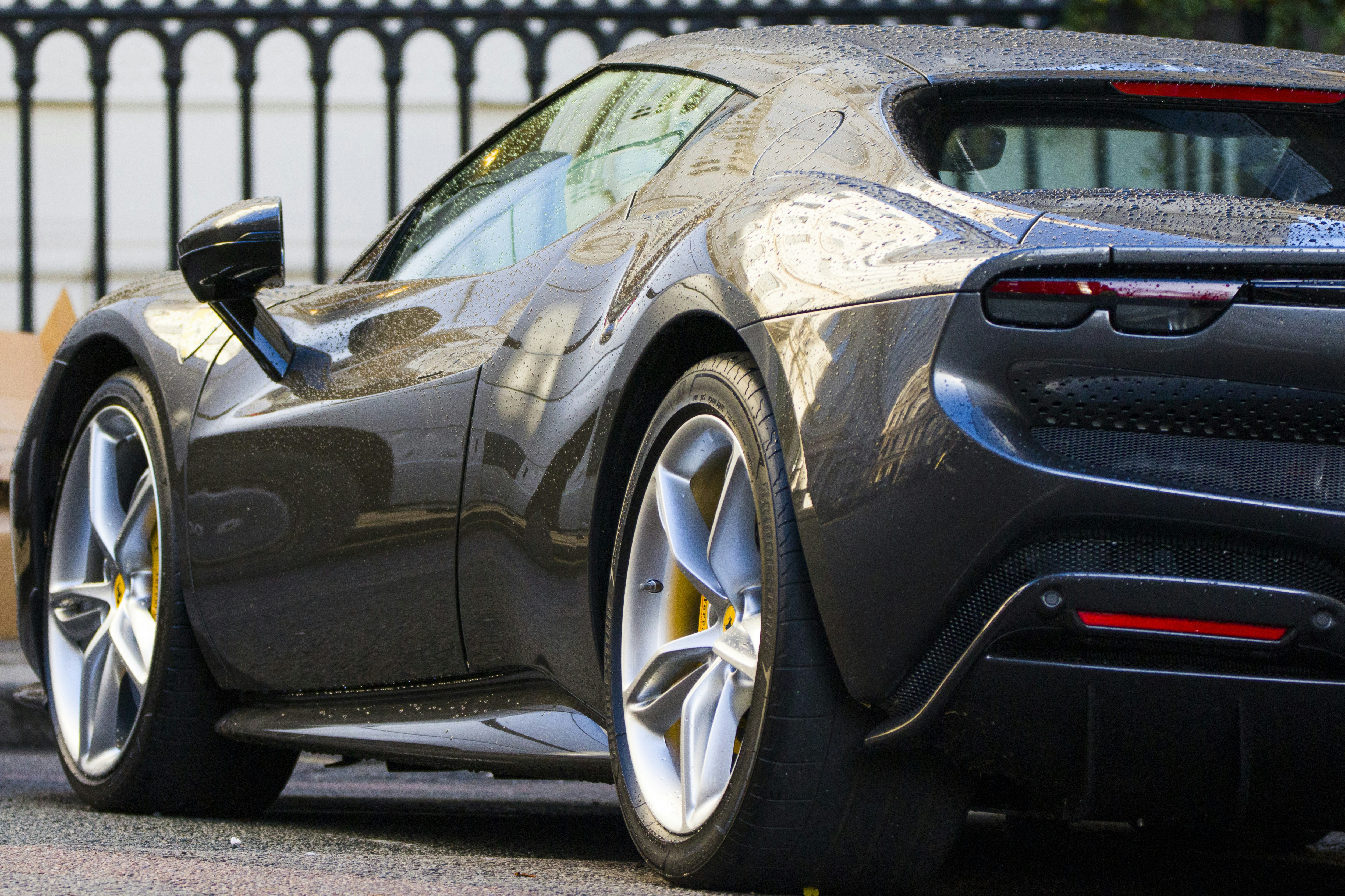 Polished silhouette: rear view of a metallic sports car after rain