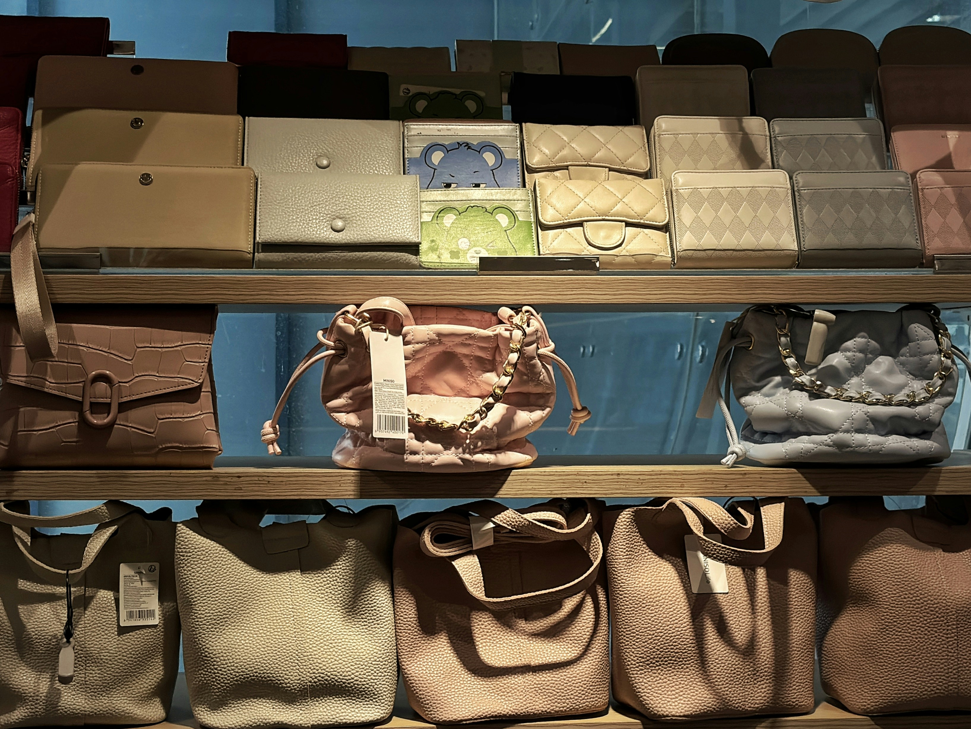 Various handbags and purses displayed on shelves in a store.