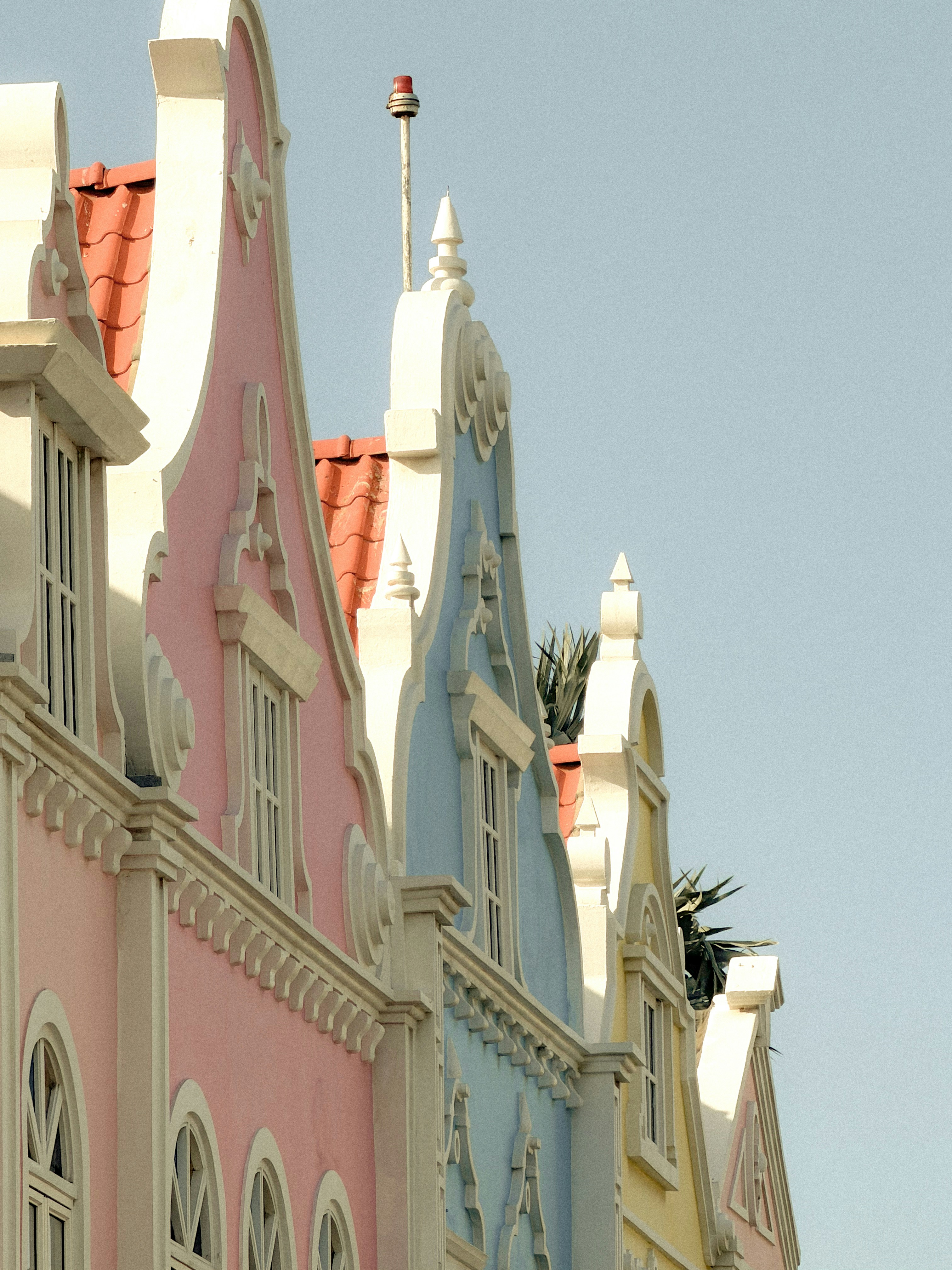 Pink, blue, and yellow gabled buildings with white trim.