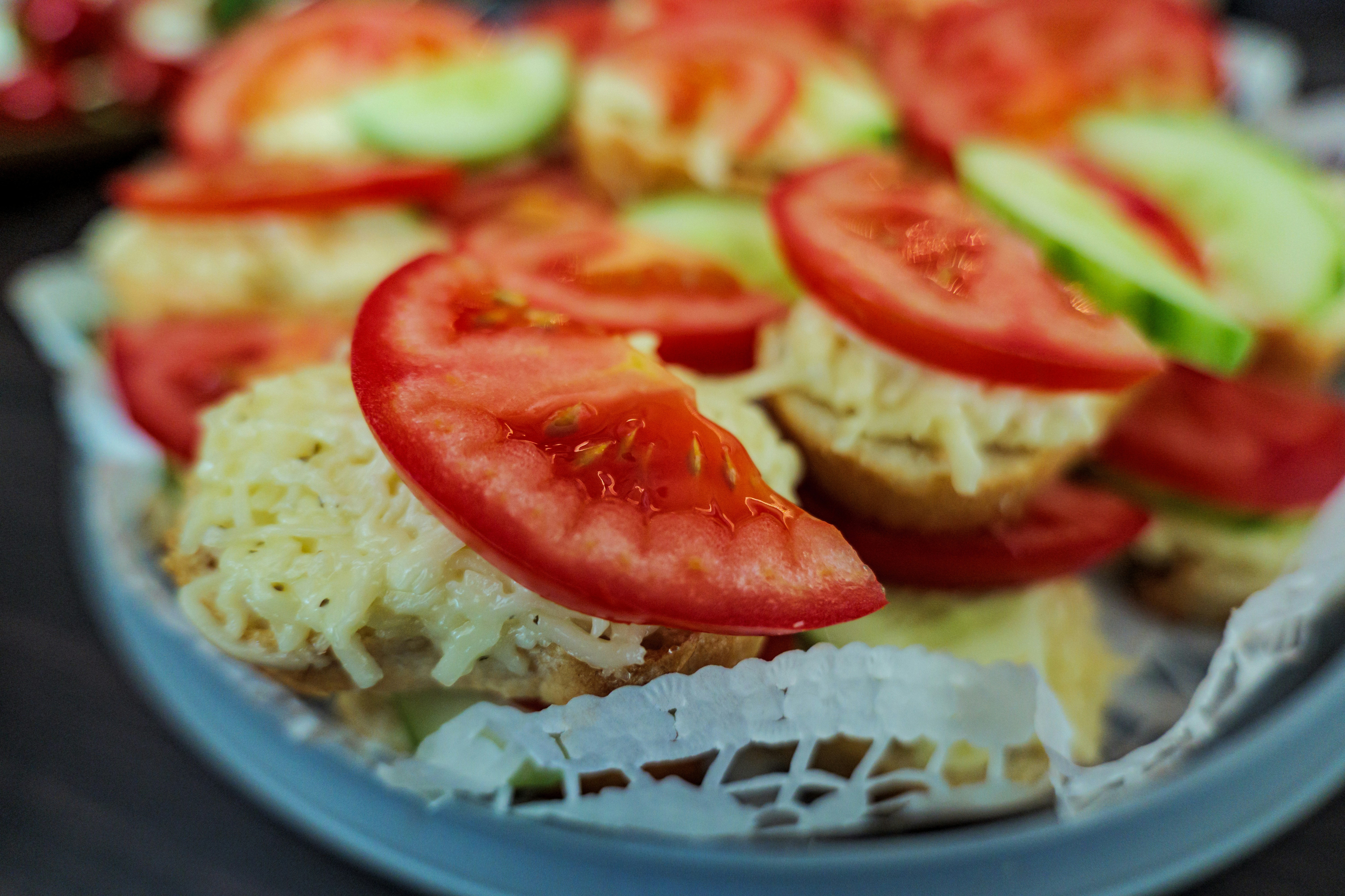 Small toasts with grated cheese and tomato slices.