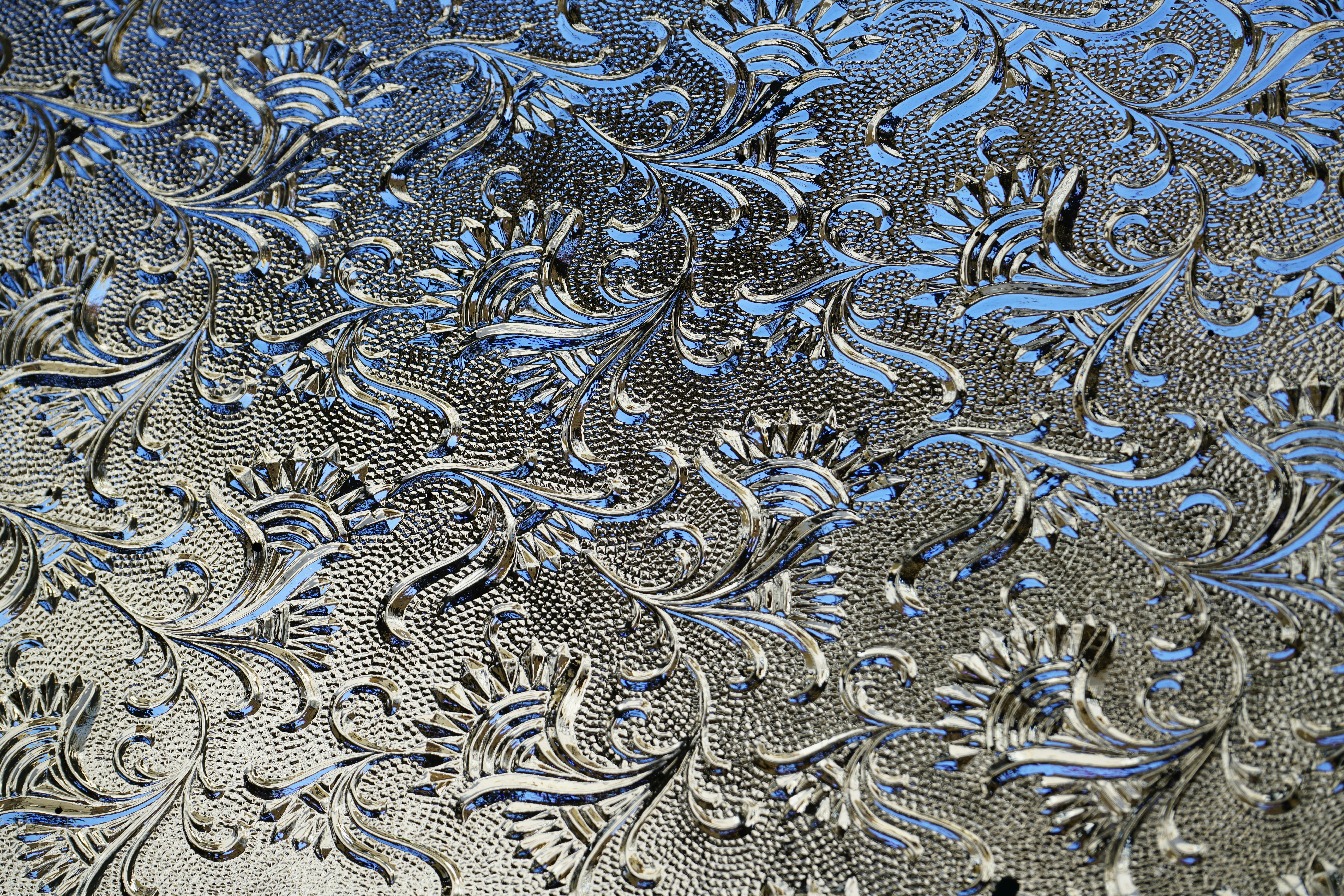 Frosted Floral Lattice: Intricate Ice Patterns on Blue-Gray Glass