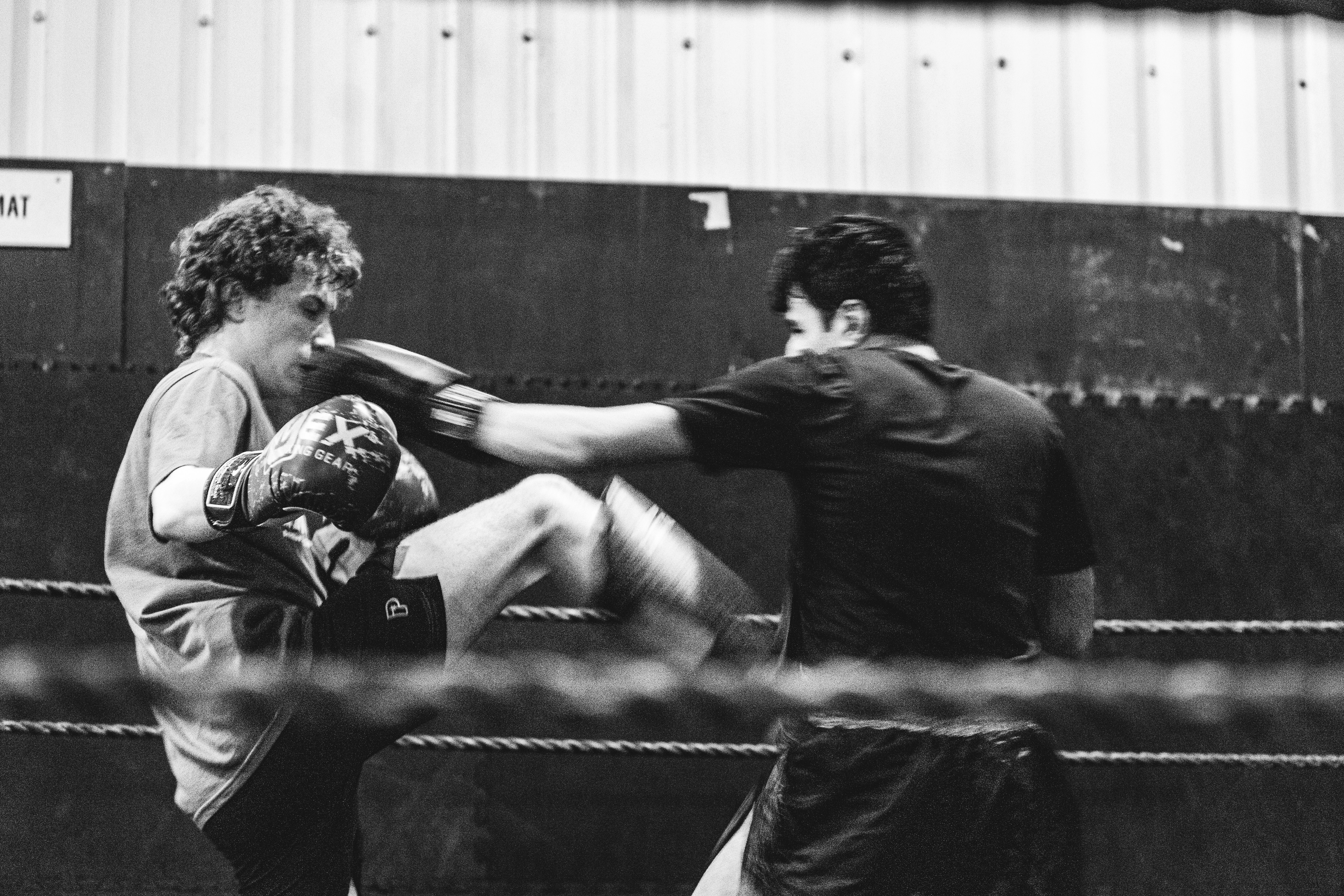 Two fighters in a high-speed exchange inside a gritty gym