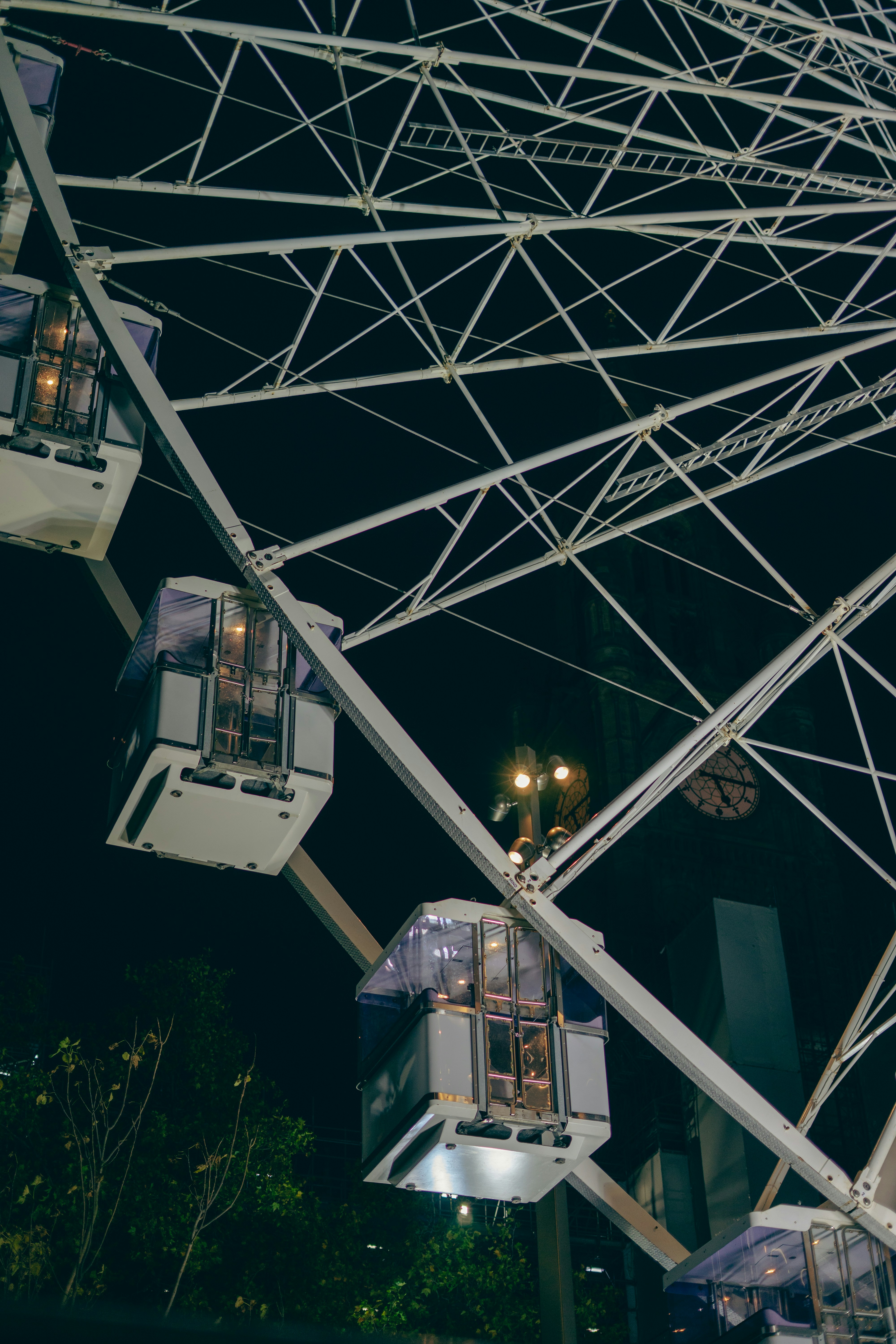 Night ride on the ferris wheel: glass cabins gliding along a lattice of steel